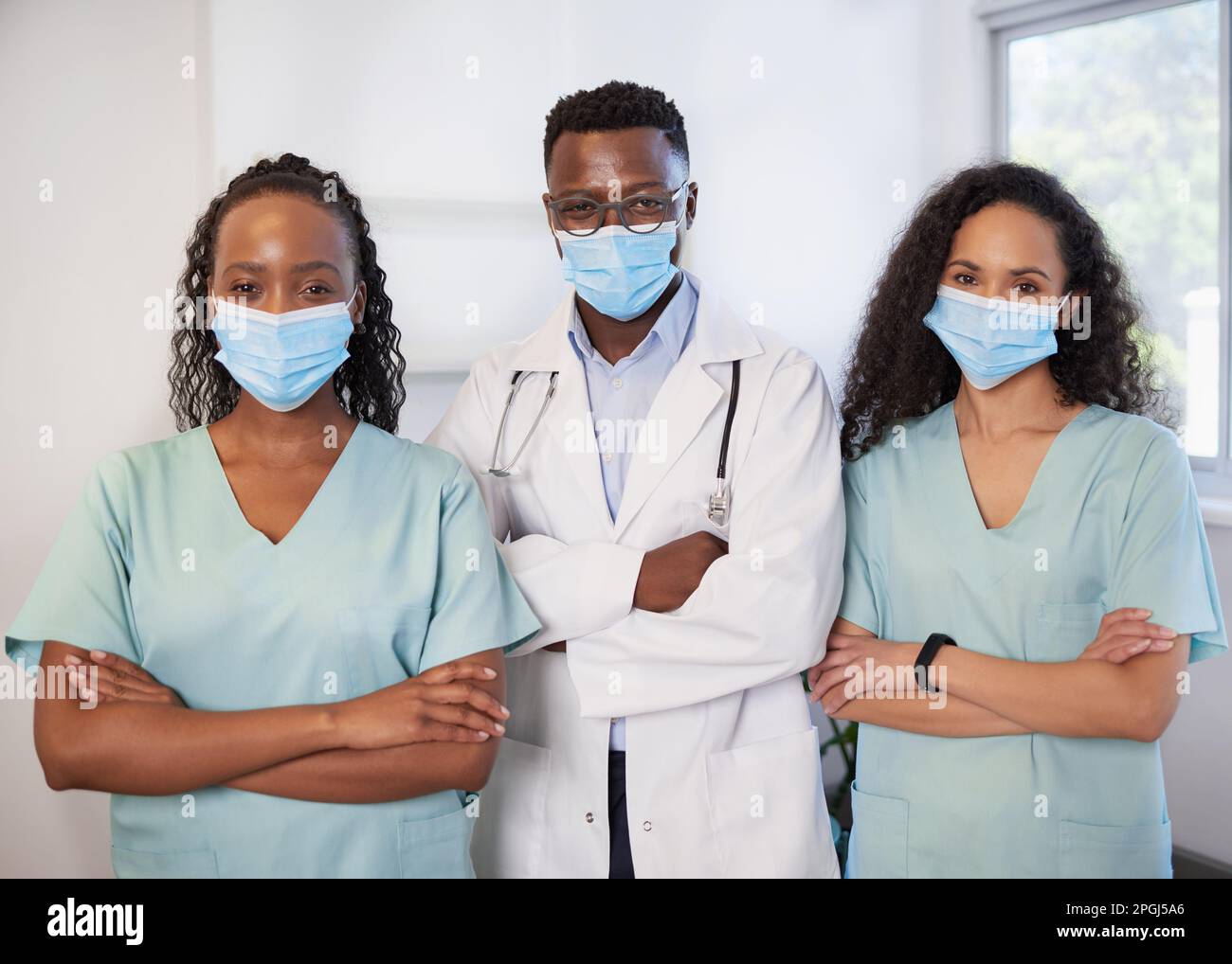Portrait of surgical team wearing masks, doctor and nurses in a row ...