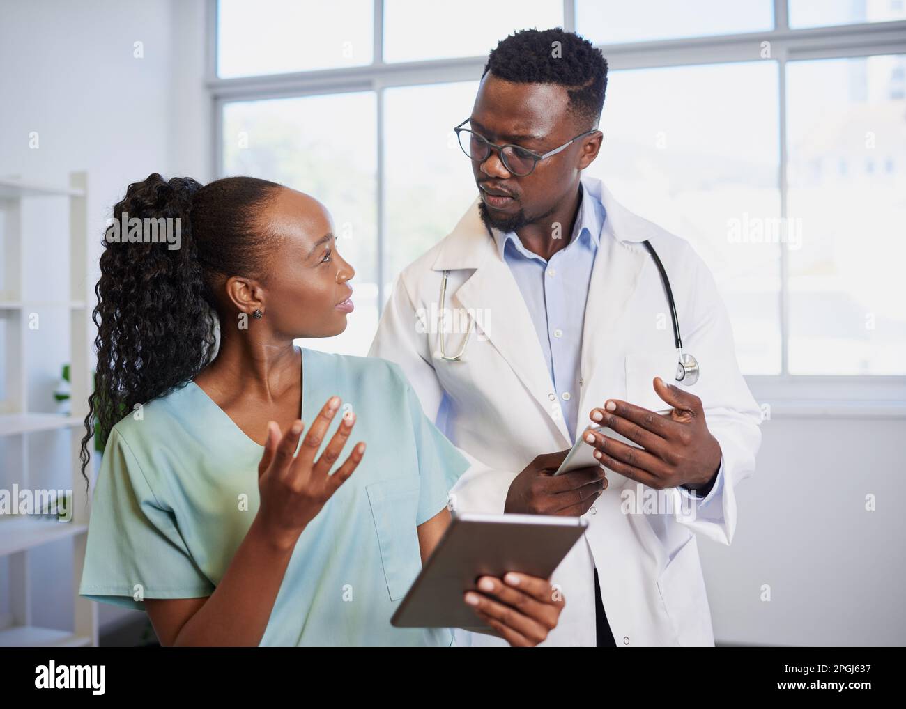Two Black medical professionals have serious discussion, doctor, nurse ...