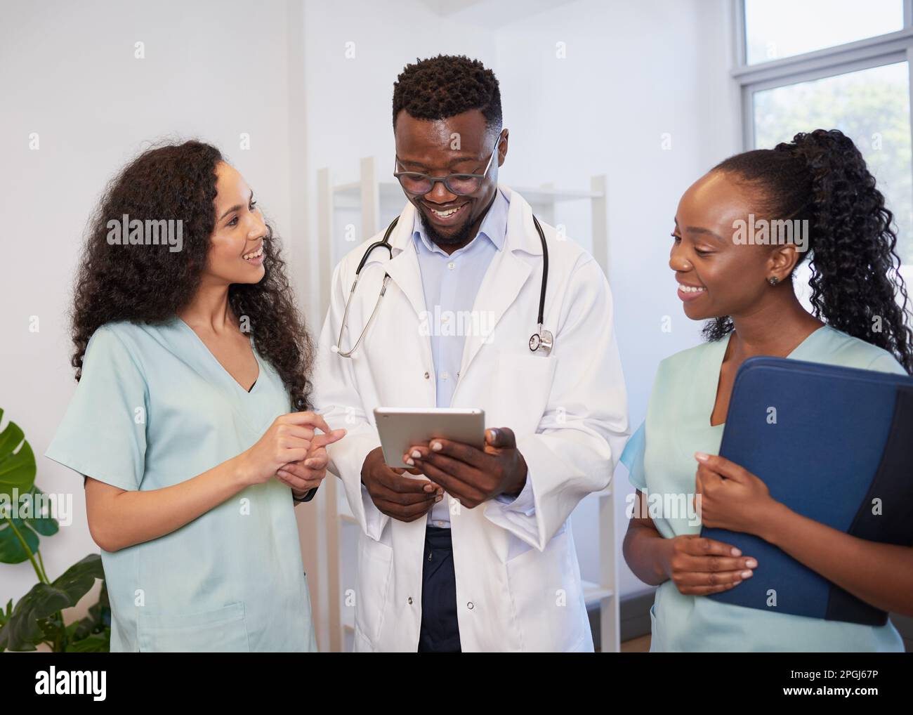 Medical teamwork as doctor and nurses stand and discuss patient care ...