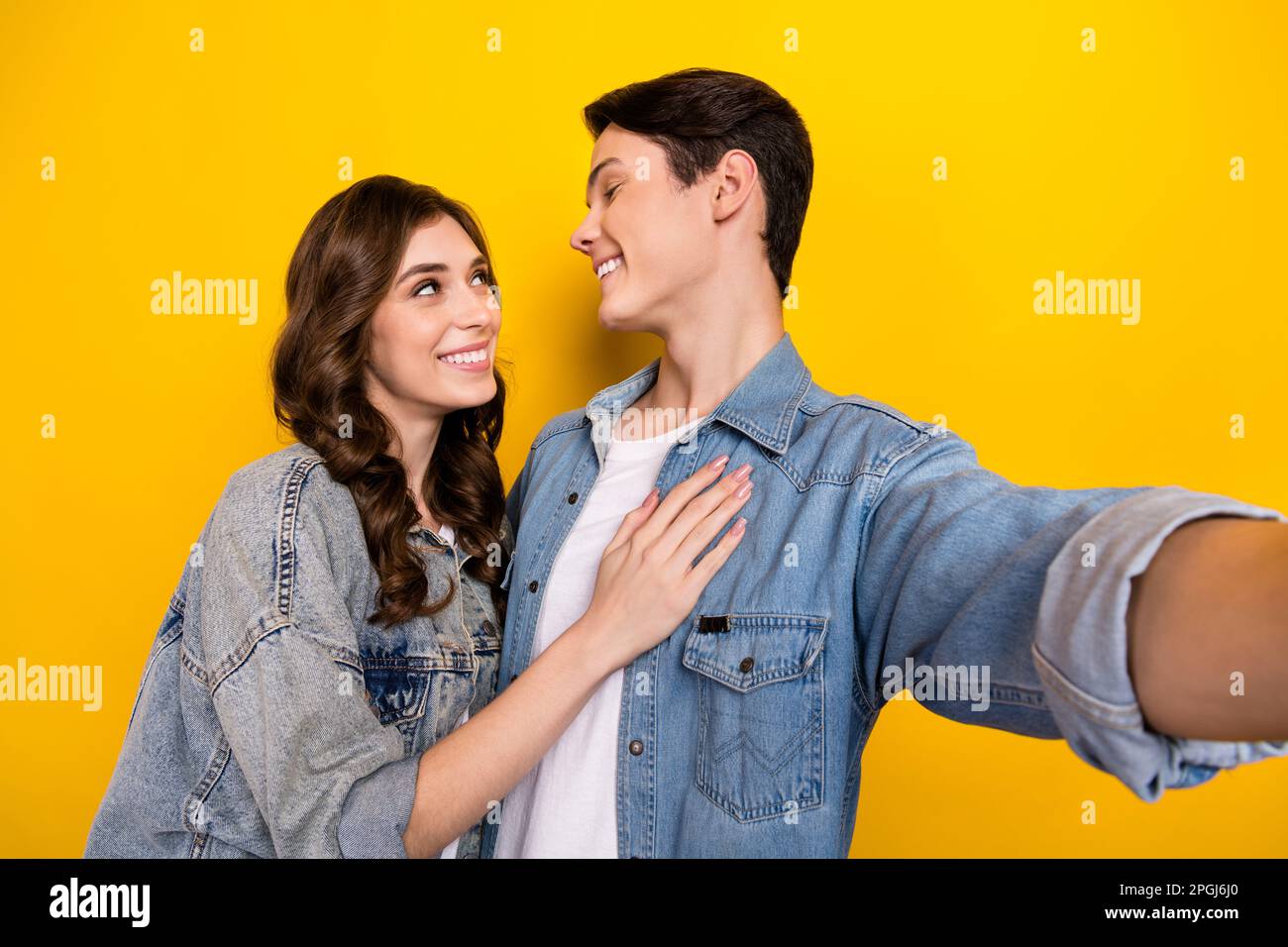 Portrait of two cheerful positive partners look each other make selfie ...