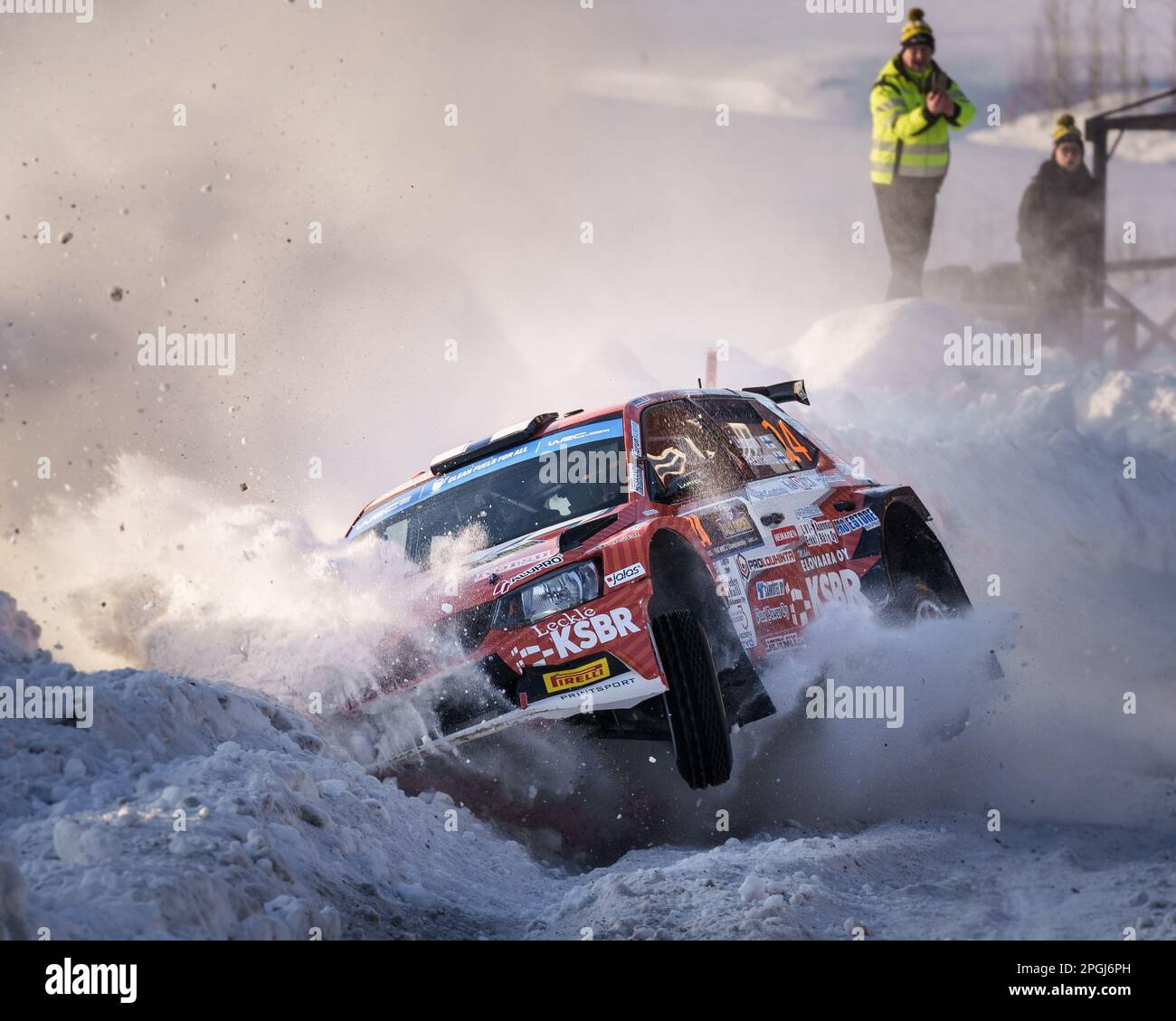 A sports car crashes into a snowdrift, kicking up a cloud of snow ...