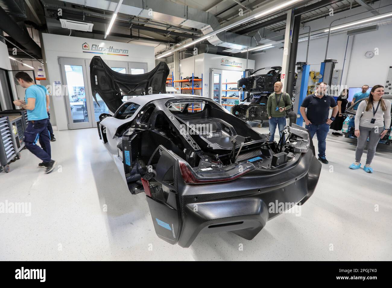 Employees working on an assembly line producing Electric Hyper car ...