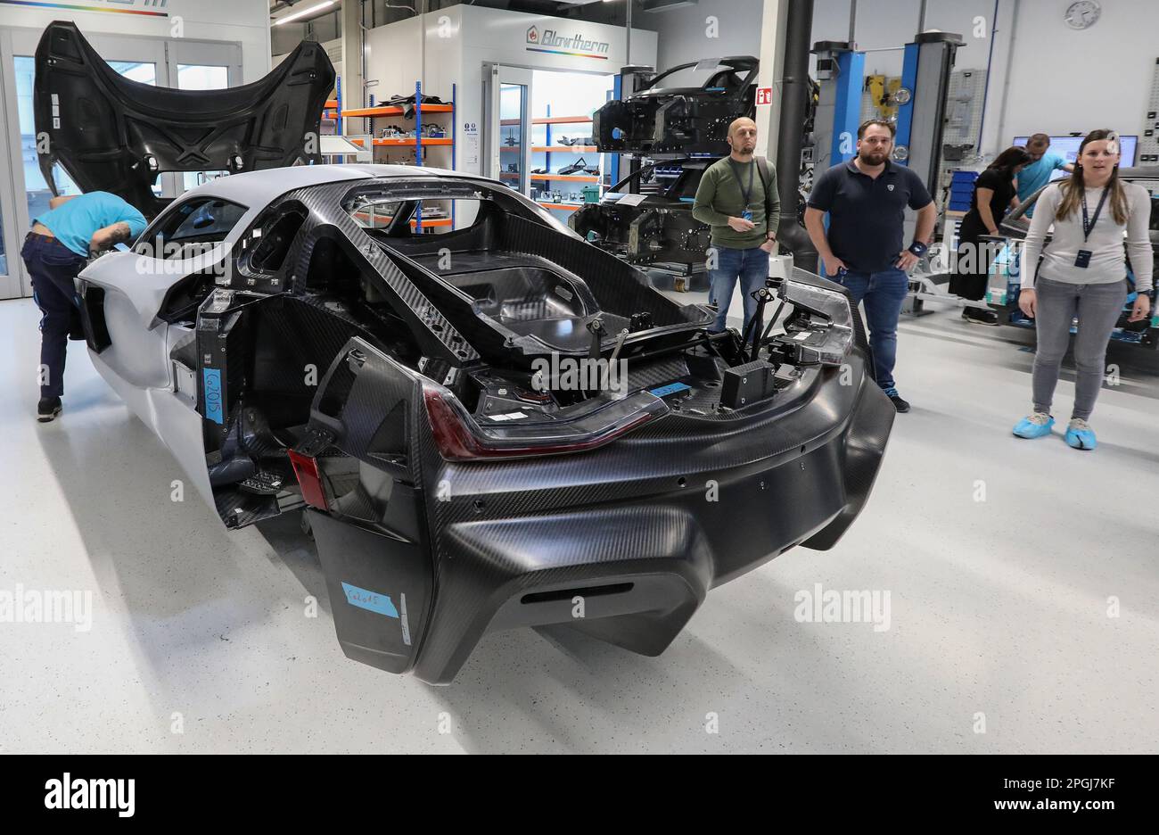 Employees working on an assembly line producing Electric Hyper car ...