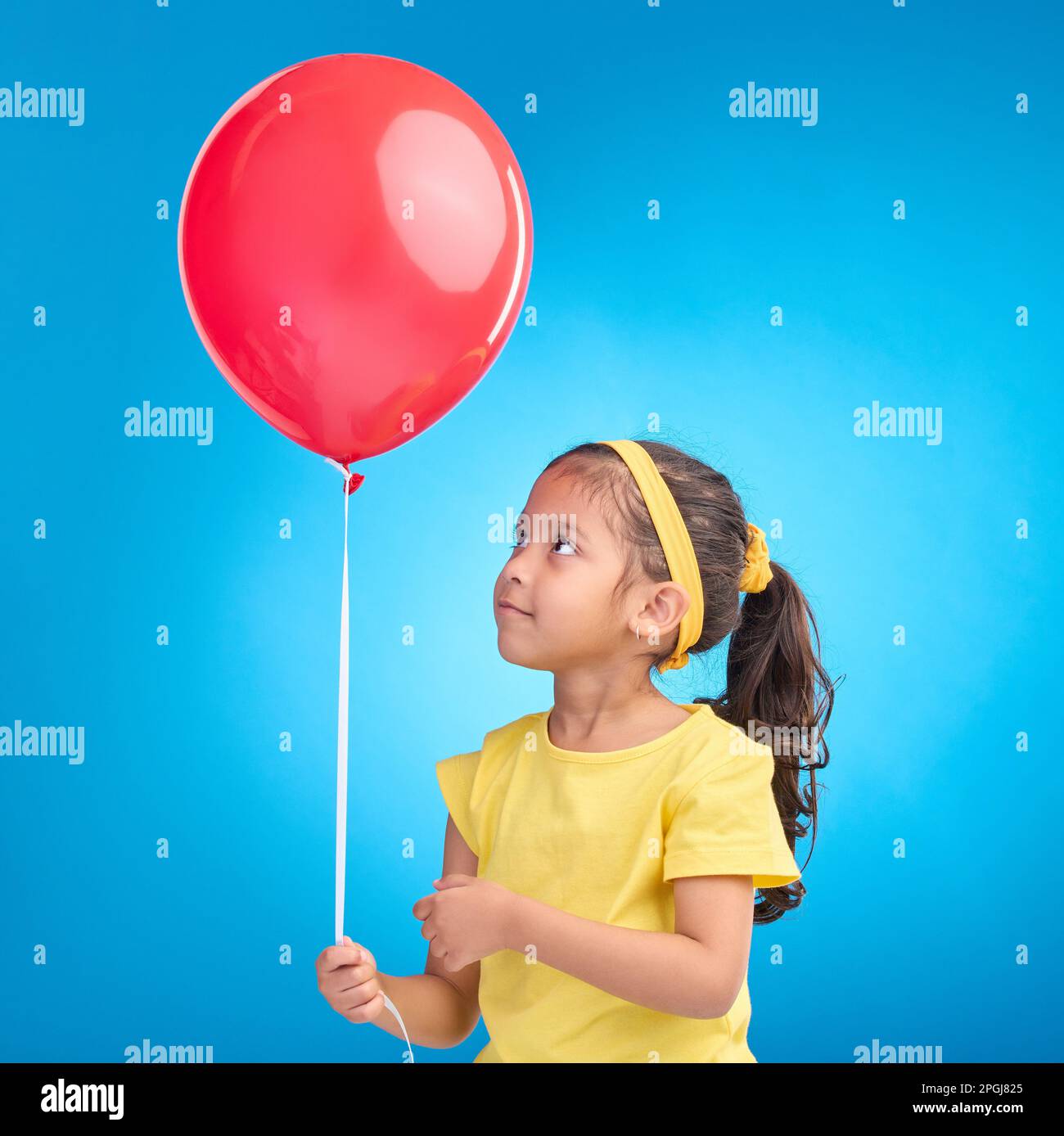 Young girl, studio and red balloon of a an kid alone ready for a ...