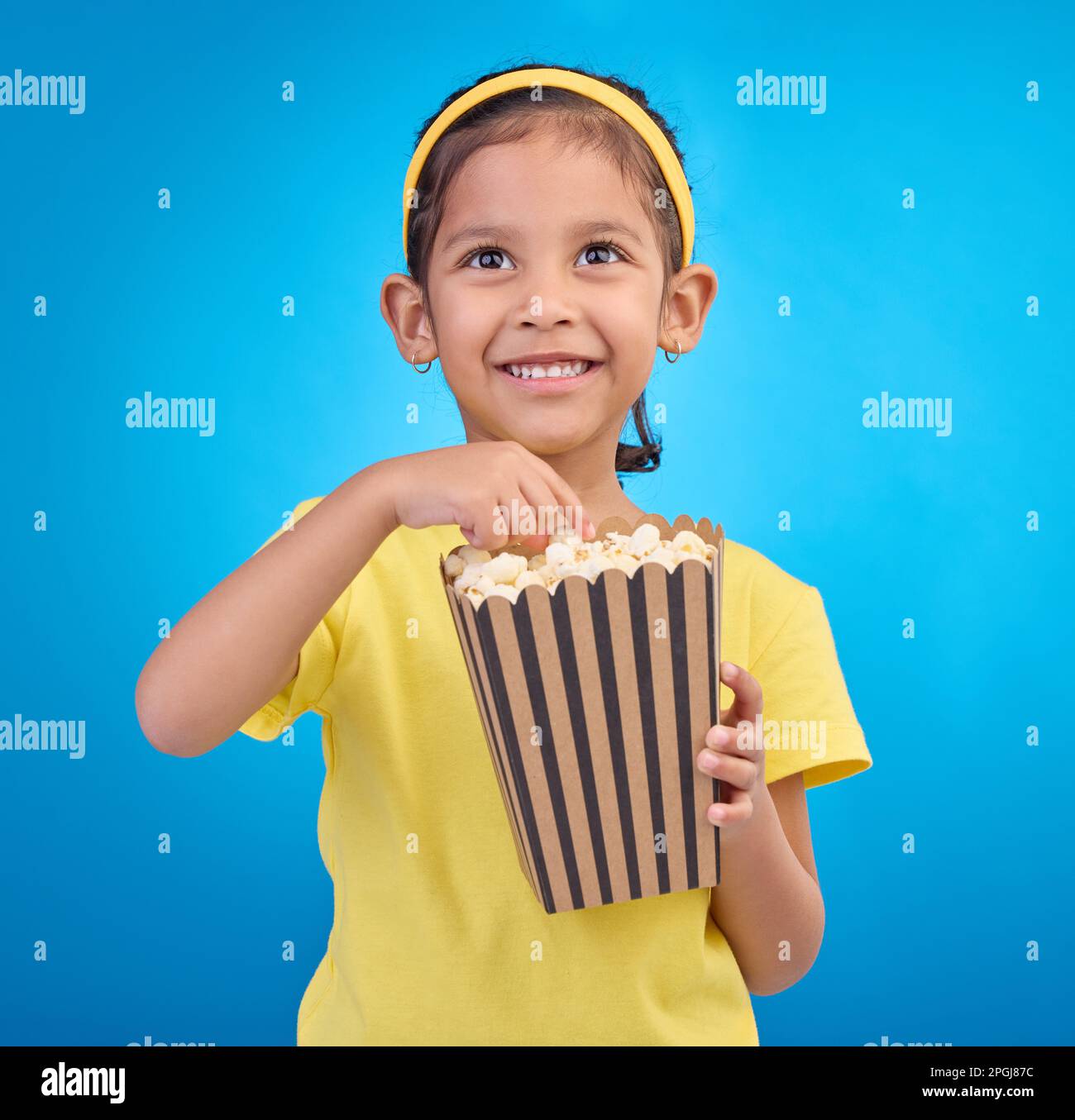 Popcorn, eating and watching movie with girl in studio for food, cinema ...