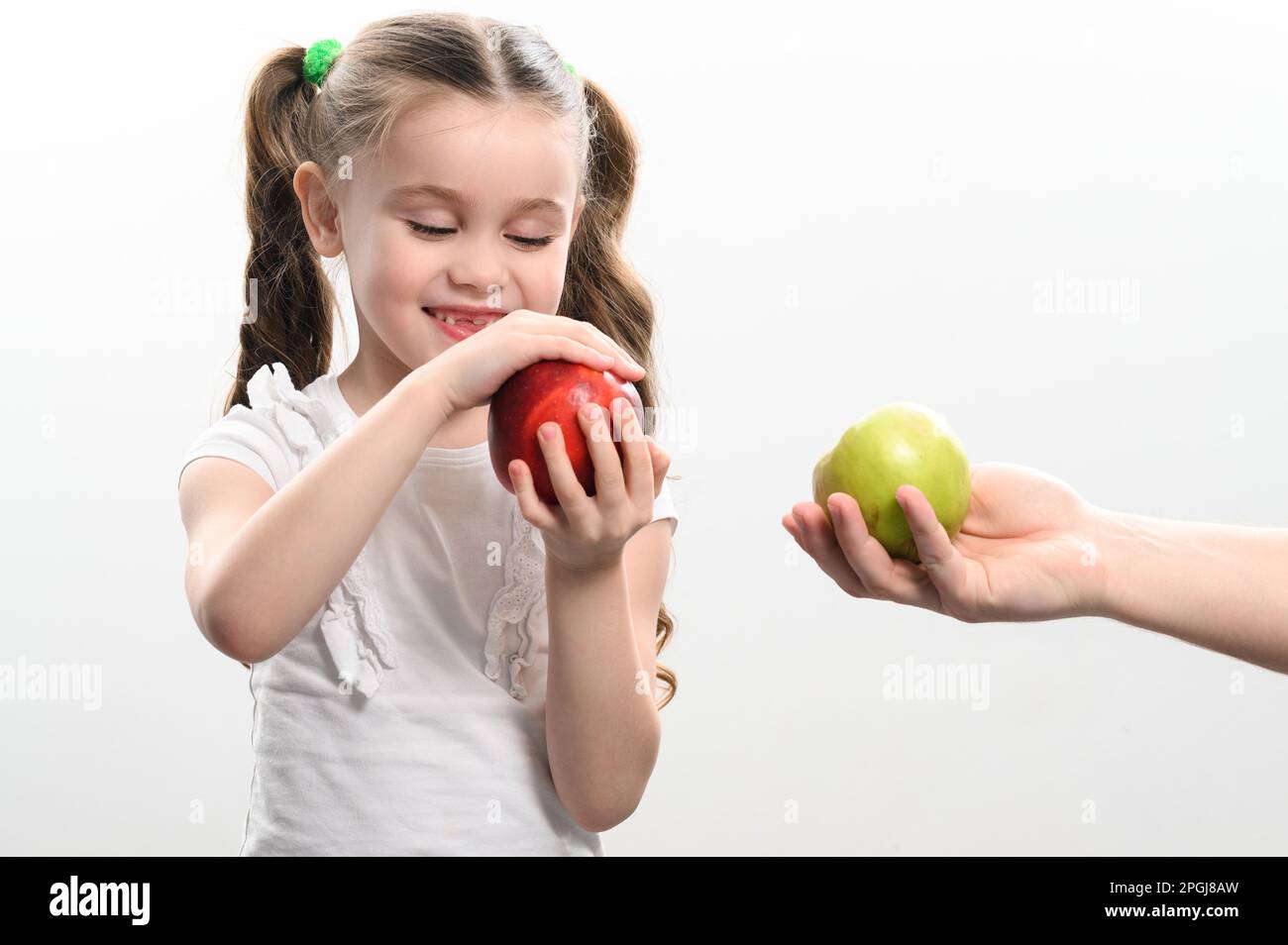 Little girl chooses between two apples, red or green apple, child's ...