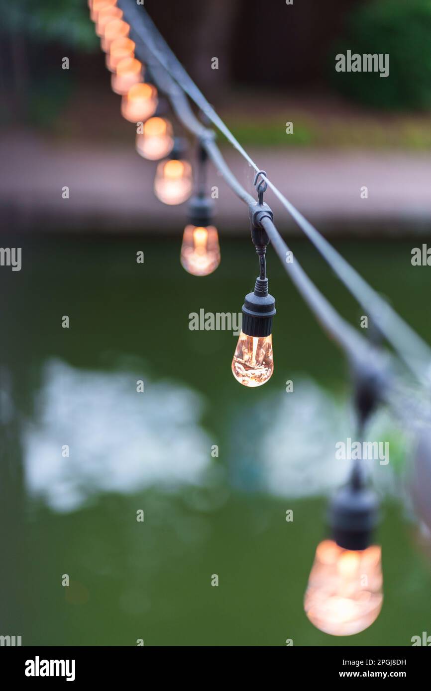 A festive string of illuminated bulbs suspended from a horizontal bar ...