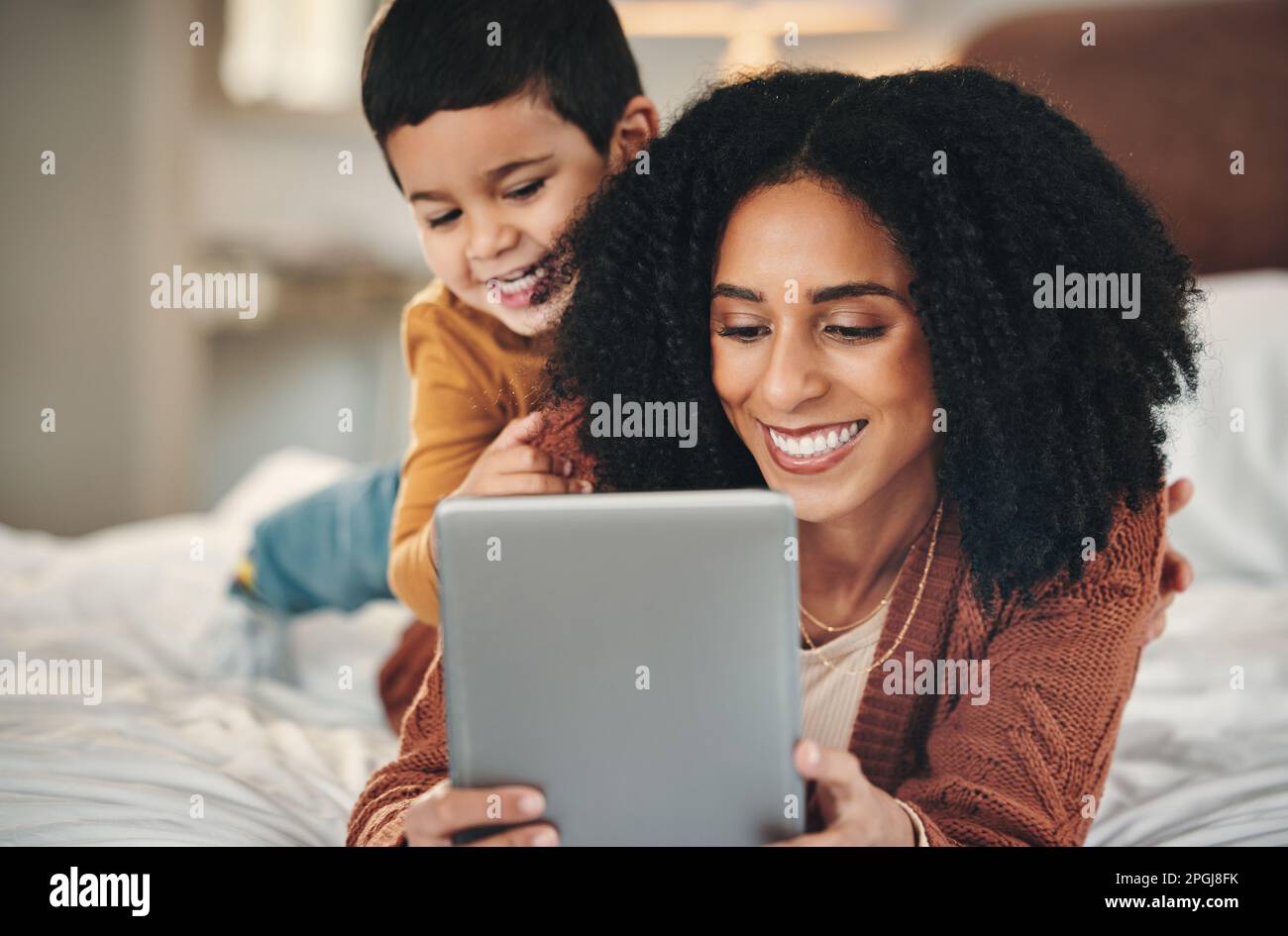 Tablet, mother and kid smile on bed, bonding and streaming movie, film ...