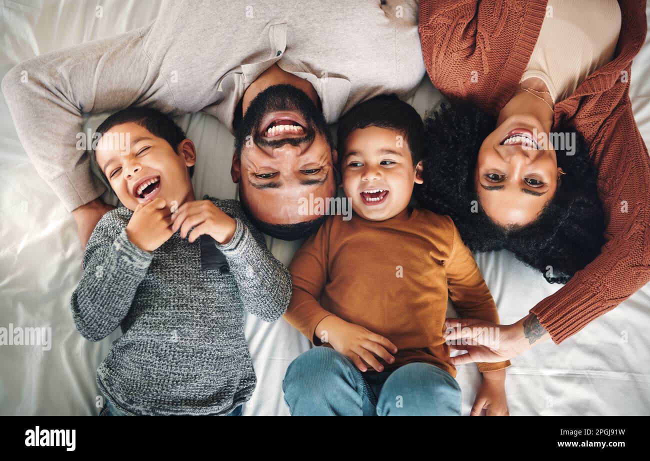 Laughing, family and top view portrait on bed in bedroom, bonding and ...