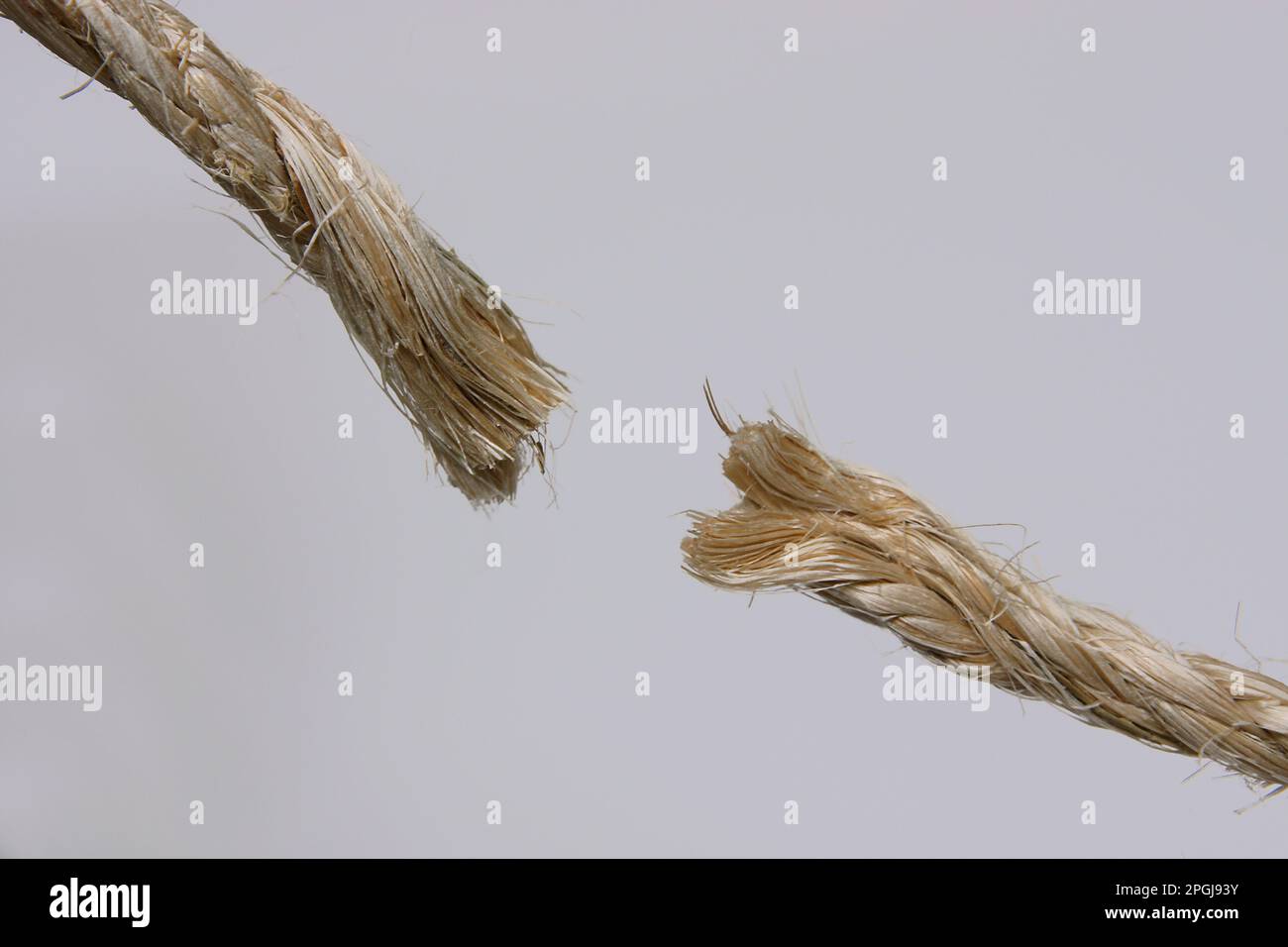 torn rope against grey background Stock Photo - Alamy