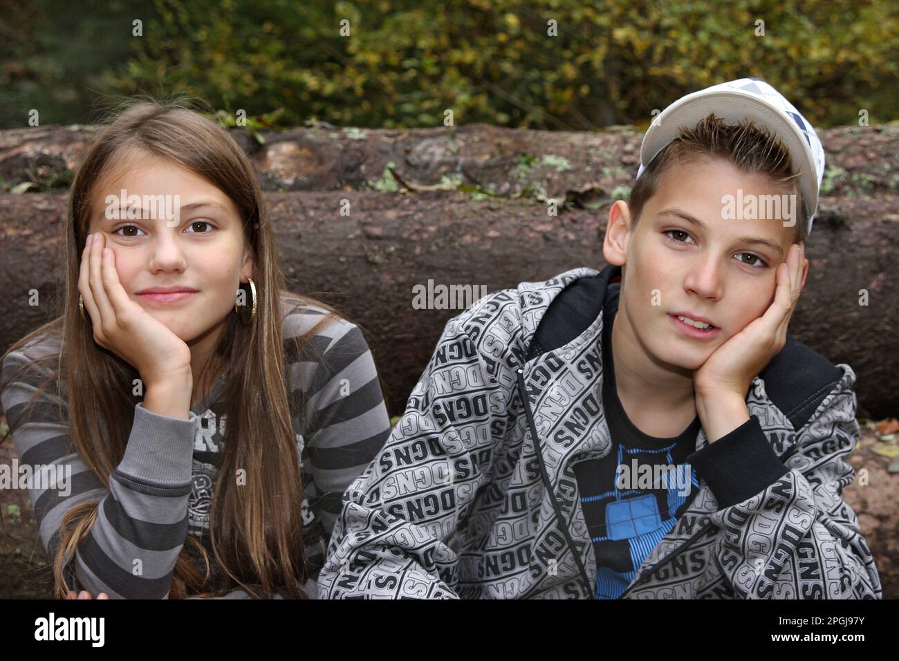 heads resting on hands teen siblings bored together in the woods Stock ...