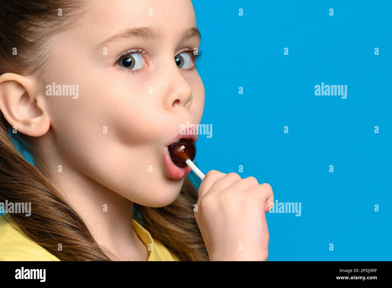 On A Blue Background A Girl Licks A Round Lollipop Close Up Caries And Bad Food For Teeth