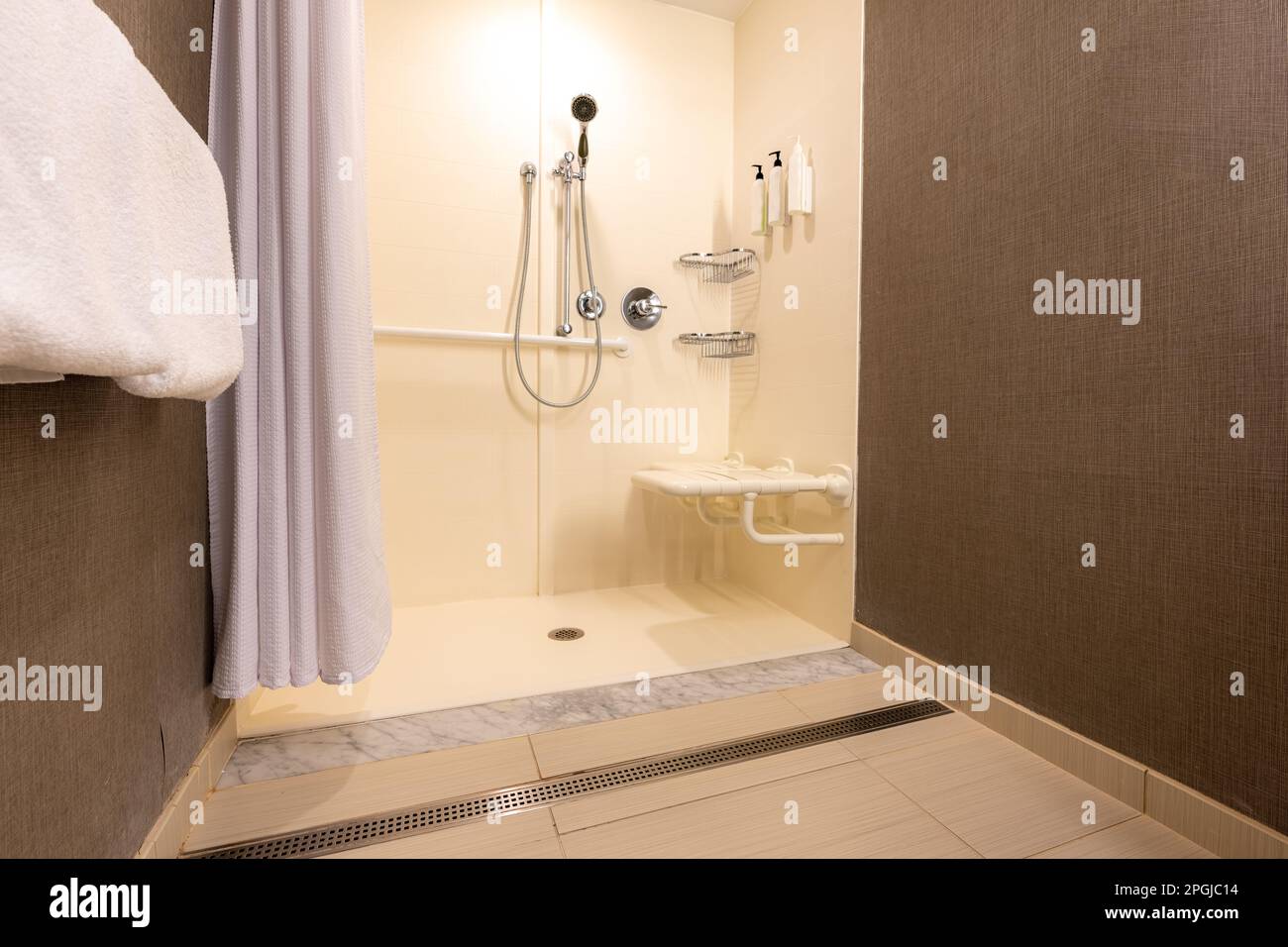 Wheelchair accessible hotel bathroom shower with tile floor and walls ...