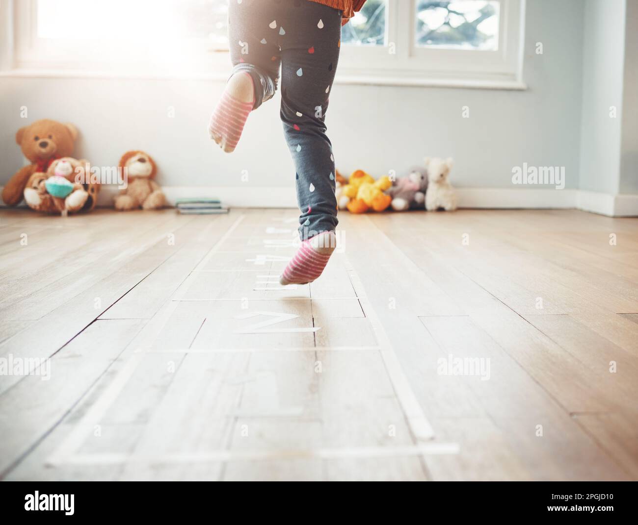 Hopscotch, happy and feet of child play in home having fun, enjoying ...