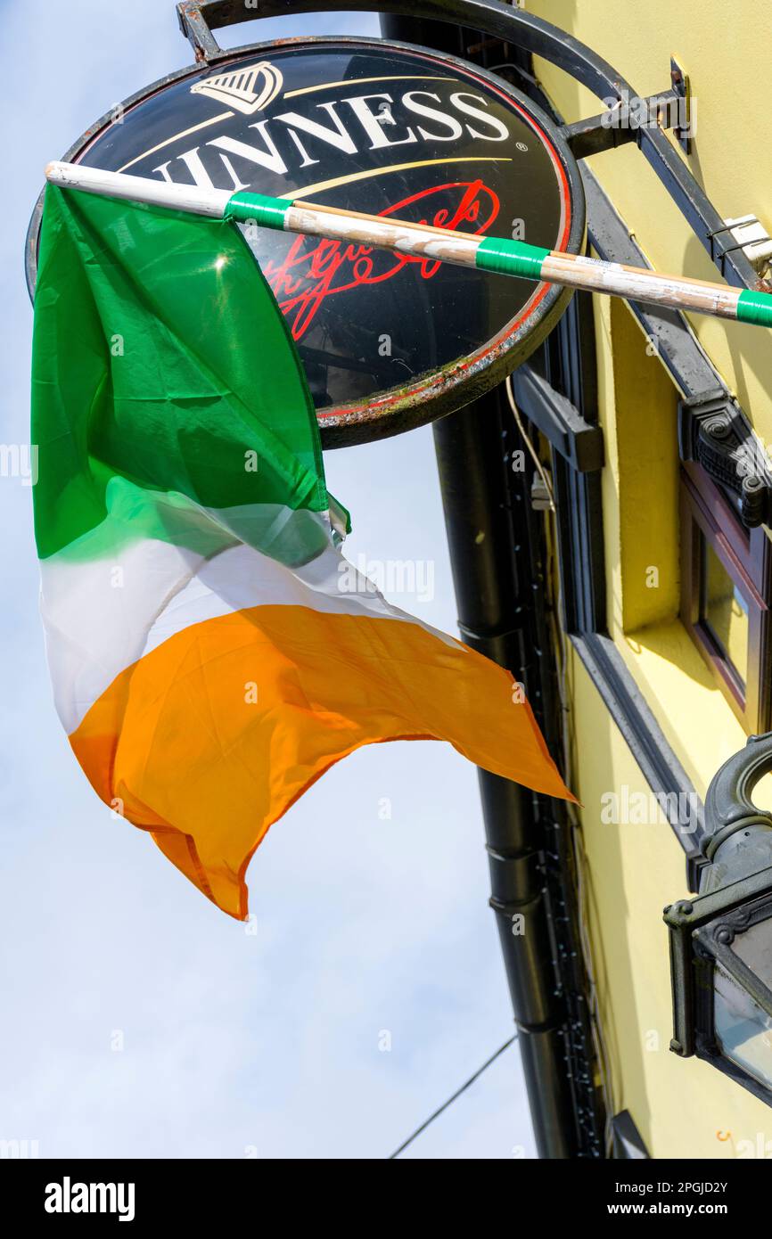 Irish tricolor national flag and Guinness sign outside a bar in County ...