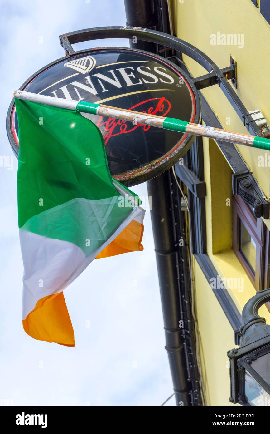 Irish tricolor national flag and Guinness sign outside a bar in County ...