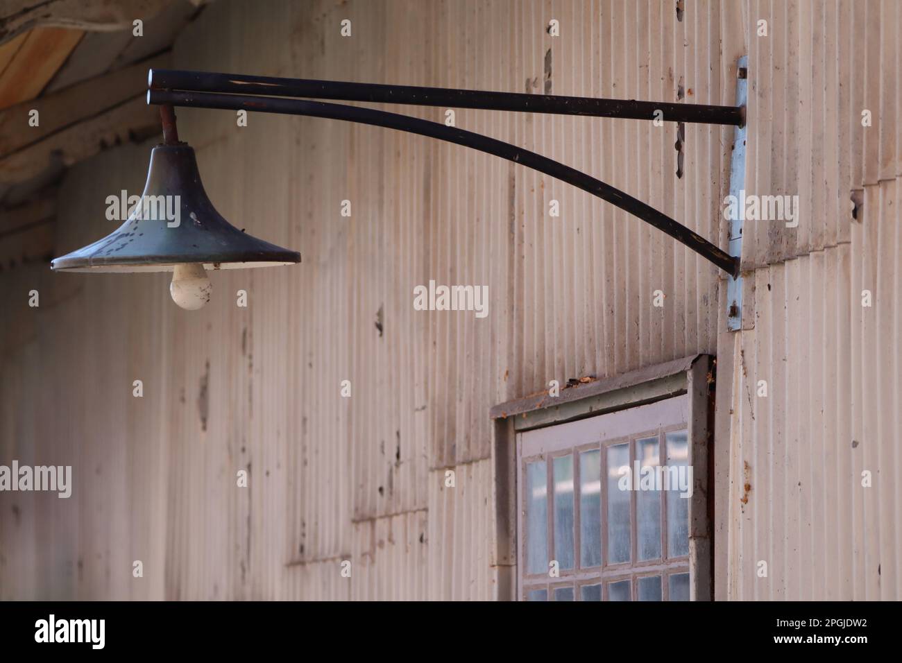 A wall-mounted light fixture illuminated near a window, providing a ...