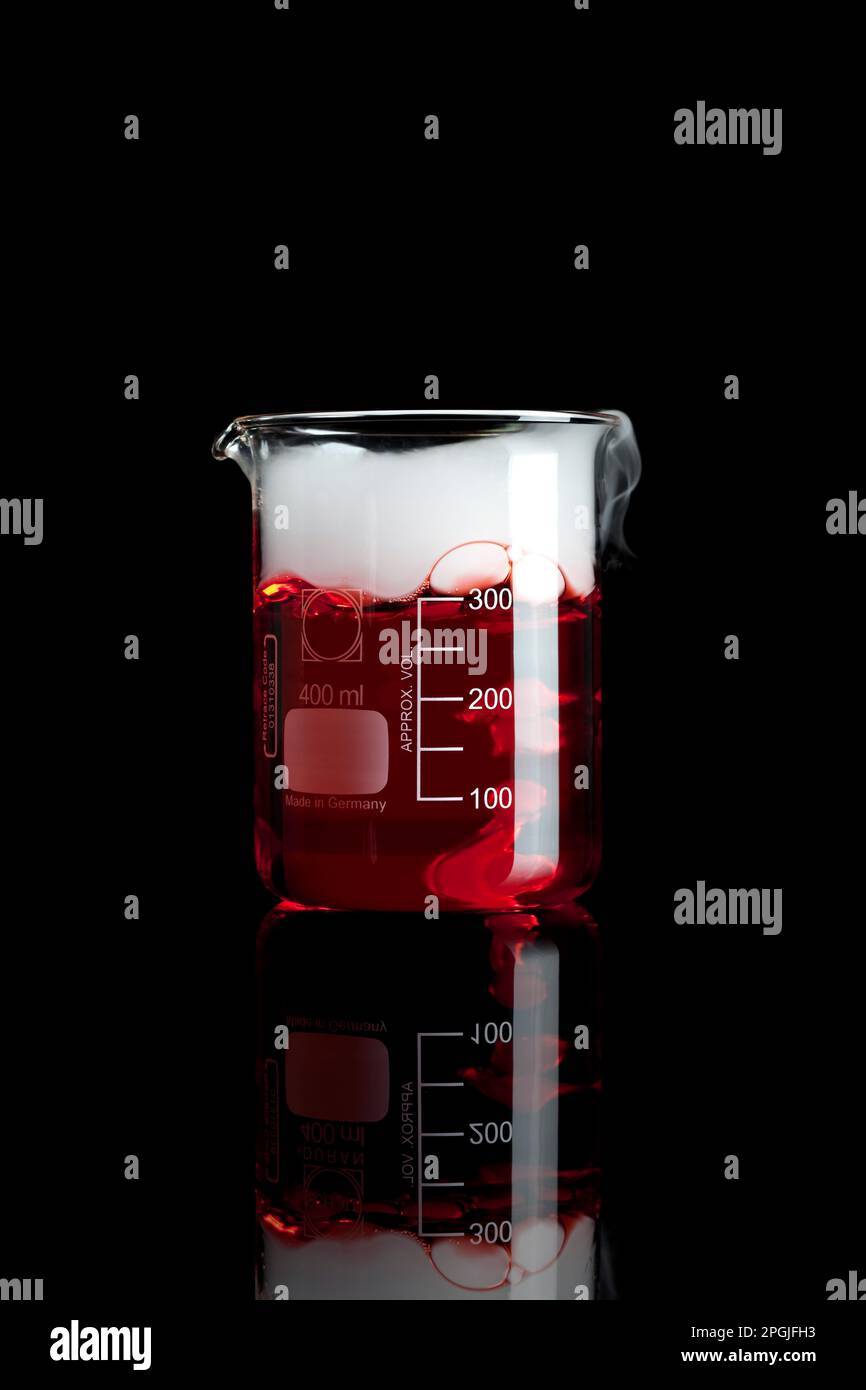 A Chemical Glasswork Beaker with Red Fluid and Smoke isolated on a ...