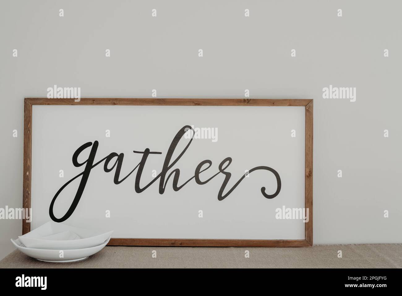 A frame with the writing "gather" next to a plate isolated on white ...