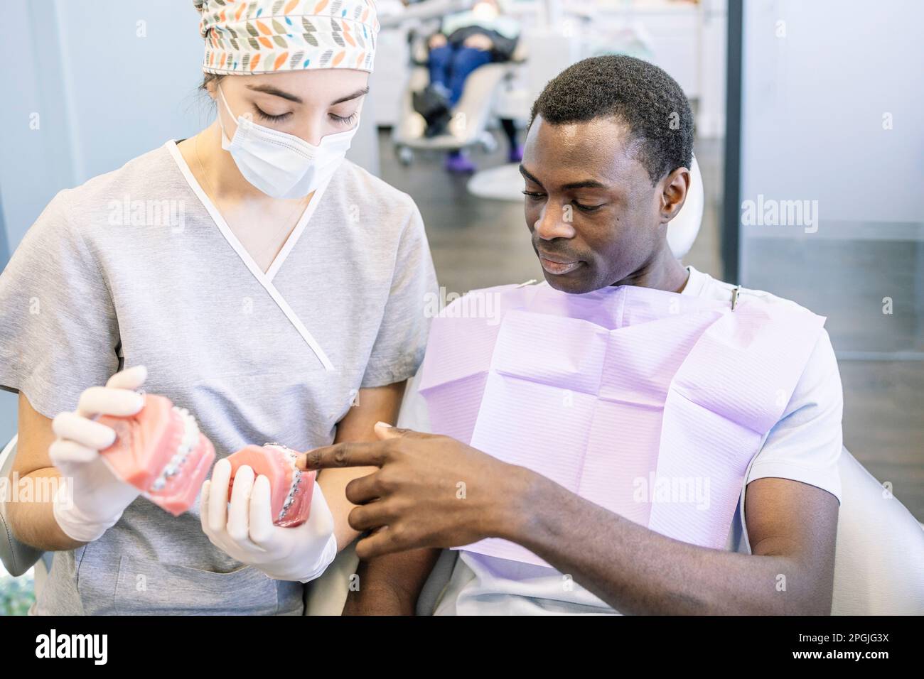 Dentist teaching Aesthetic orthodontics to his patient Stock Photo - Alamy