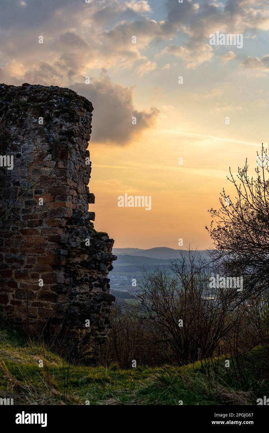An aged red-brick wall stands in front of a stunning sunset backdrop ...