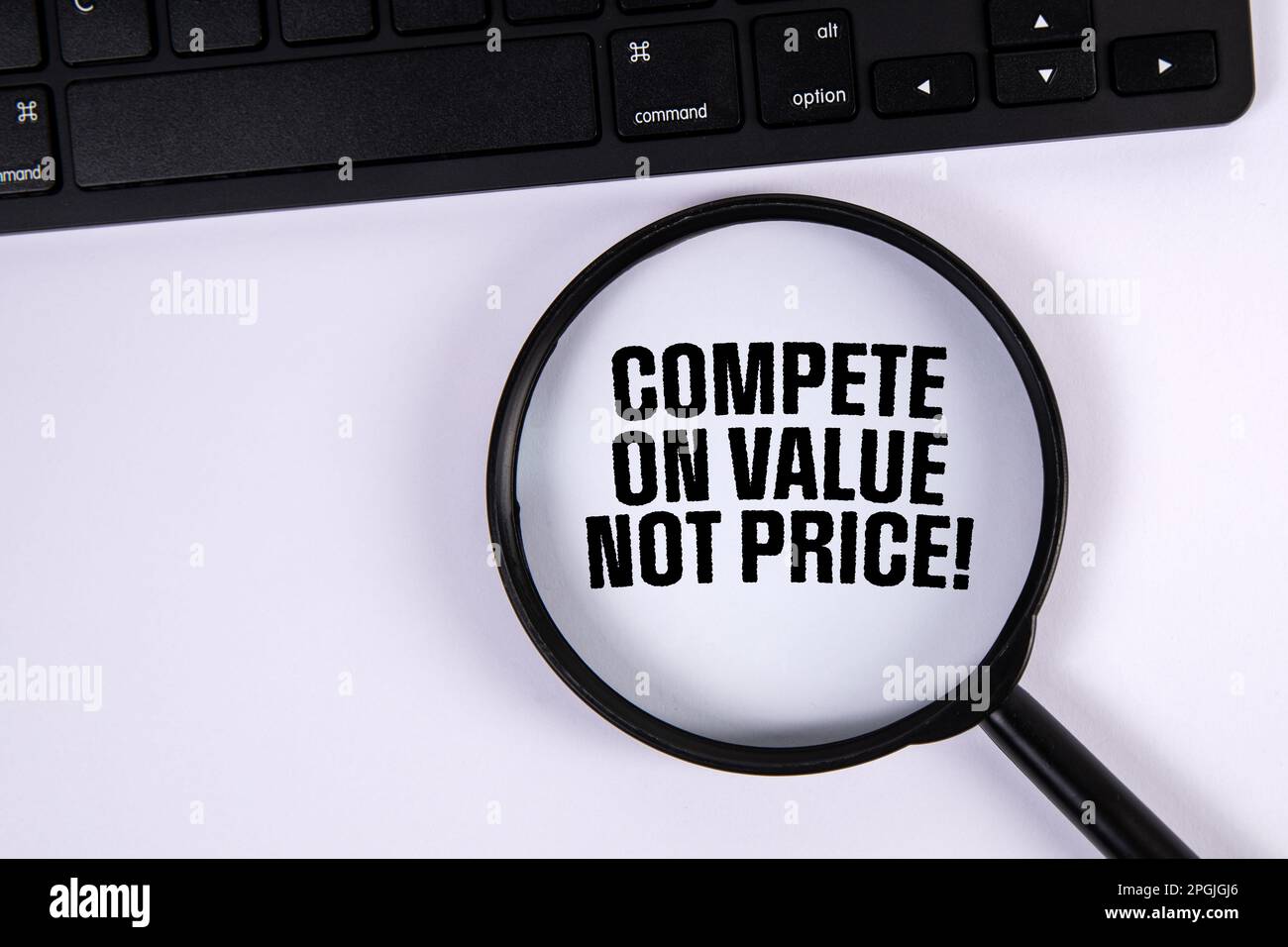 Compete on value, not price. Magnifying glass and computer keyboard on ...