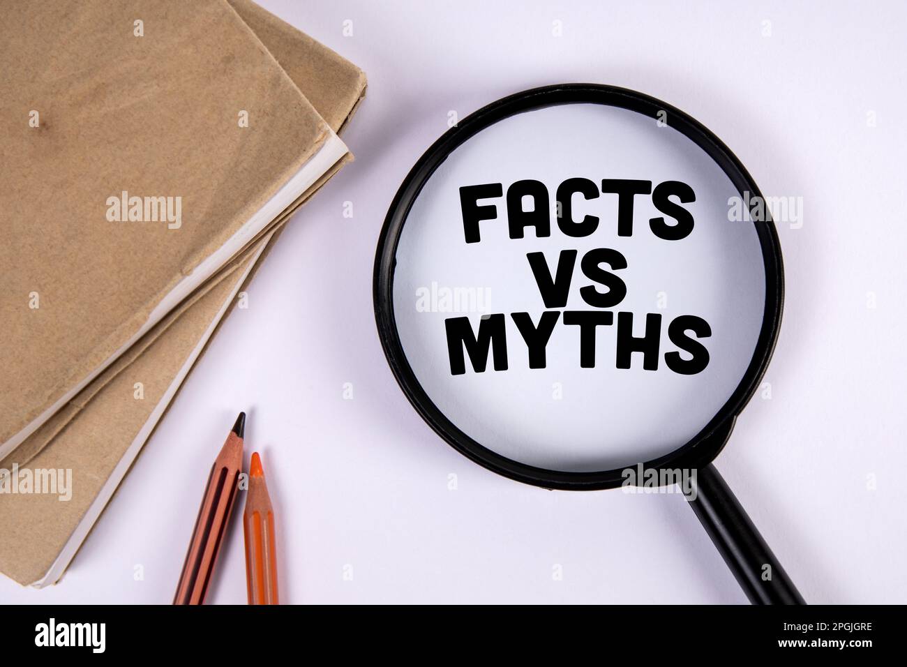 Facts vs myths concept. Magnifying glass and book on white background ...
