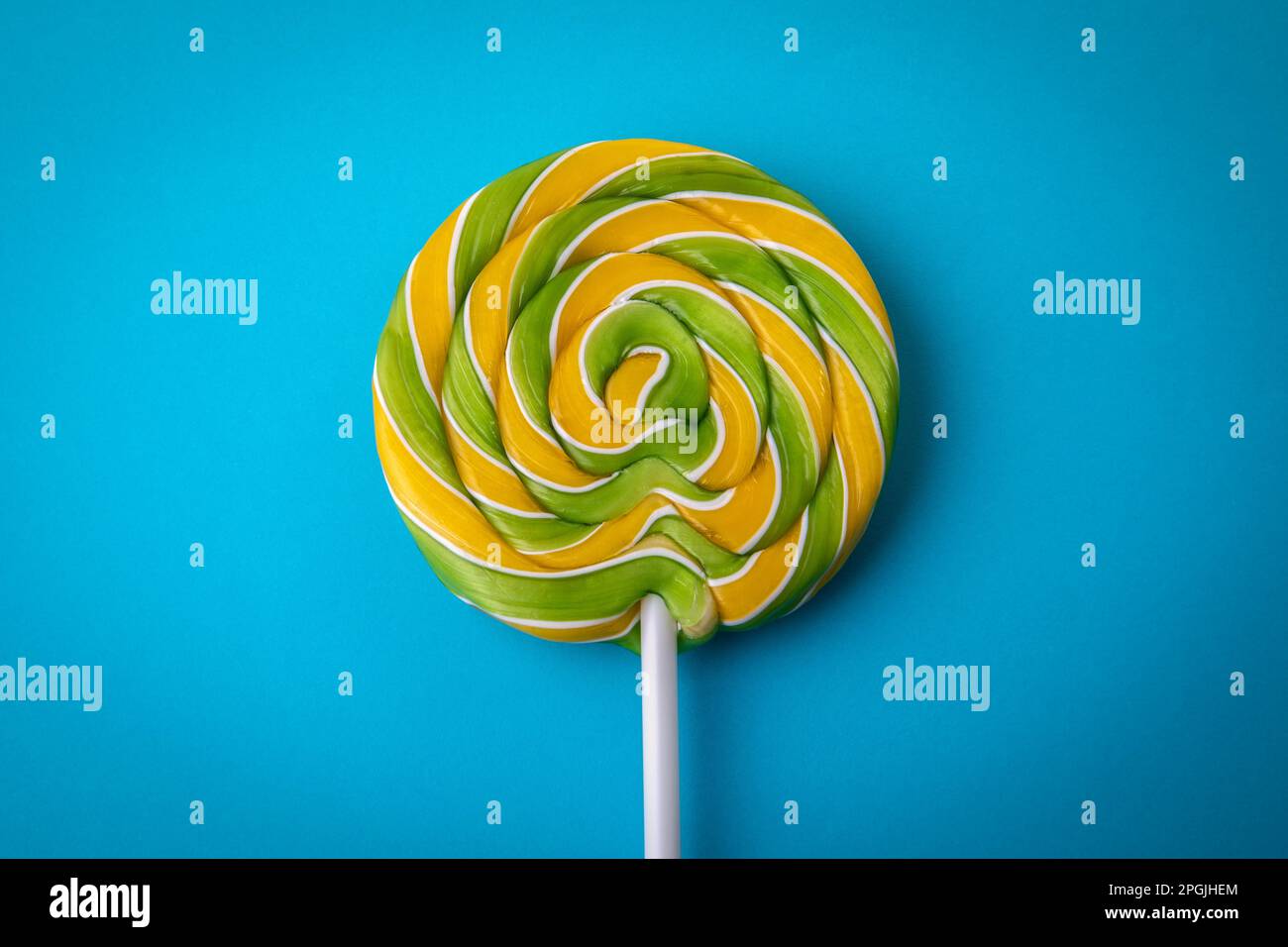 Green Yellow lollipop and blue background. Sweets and junk food Stock ...