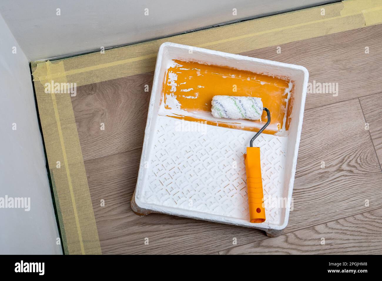Clean paint roller and an empty paint tub on the floor Stock Photo - Alamy