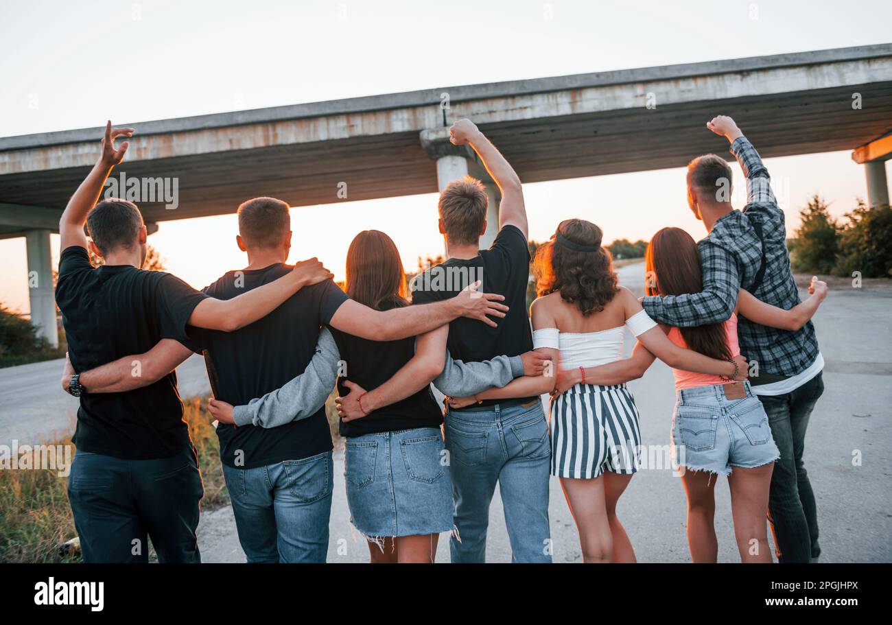 View from behind. Group of young cheerful friends having fun together ...