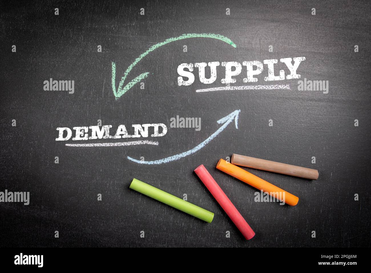Demand and Supply Concept. Text and colored pieces of chalk on a dark ...