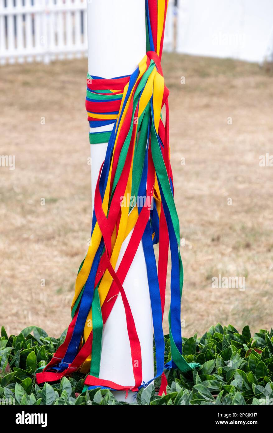 Colourful ribbons tied around the base of a traditional English Maypole ...