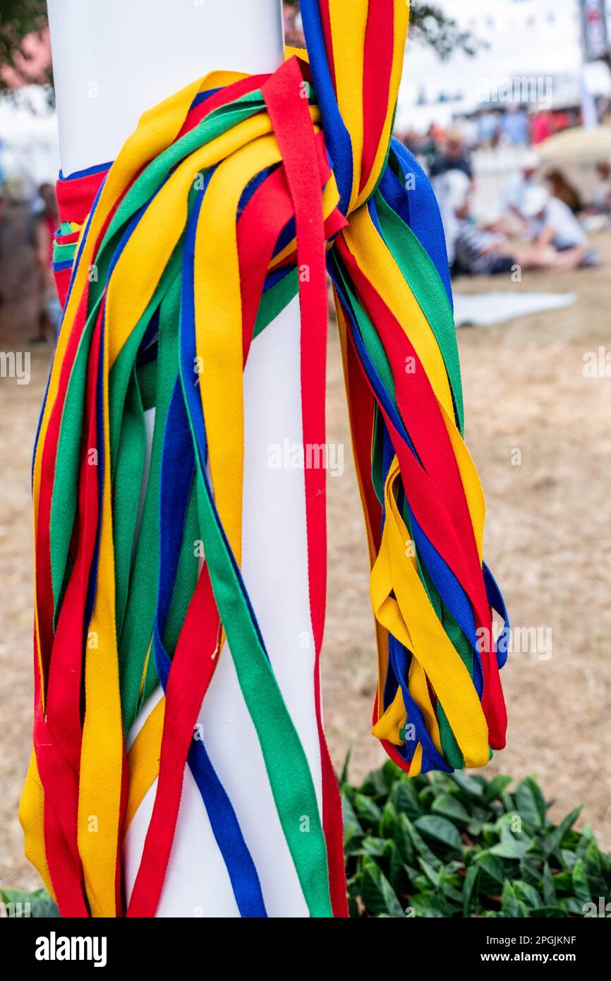 Colourful ribbons tied around the base of a traditional English Maypole ...