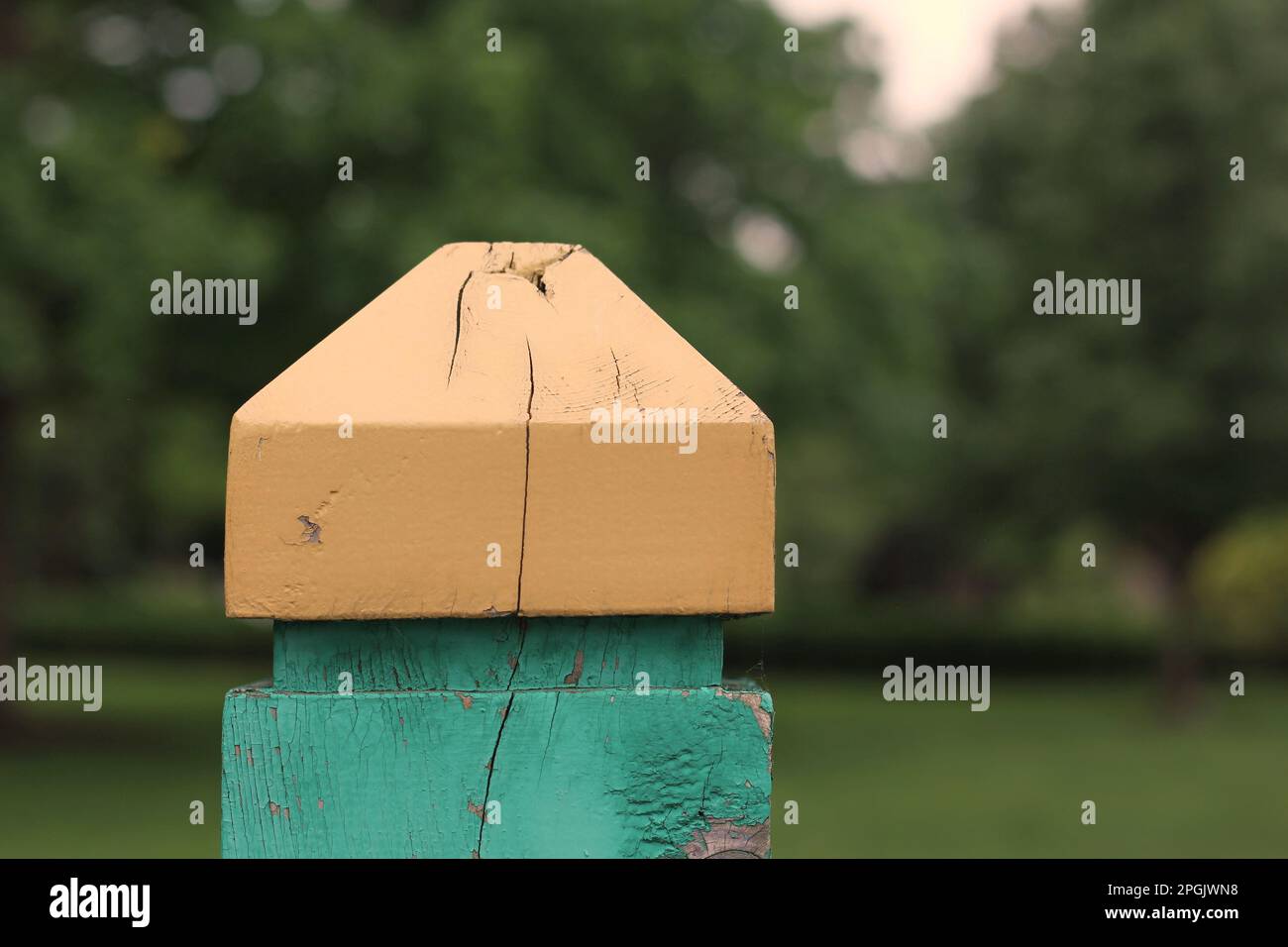 A traditional wooden fence post painted yellow and blue Stock Photo - Alamy