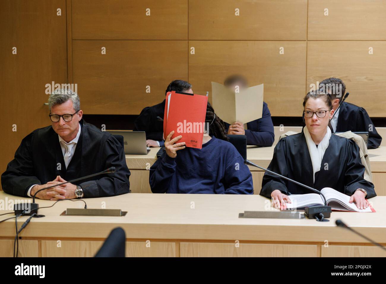 Bielefeld, Germany. 23rd Mar, 2023. Two of three defendants sit next to ...