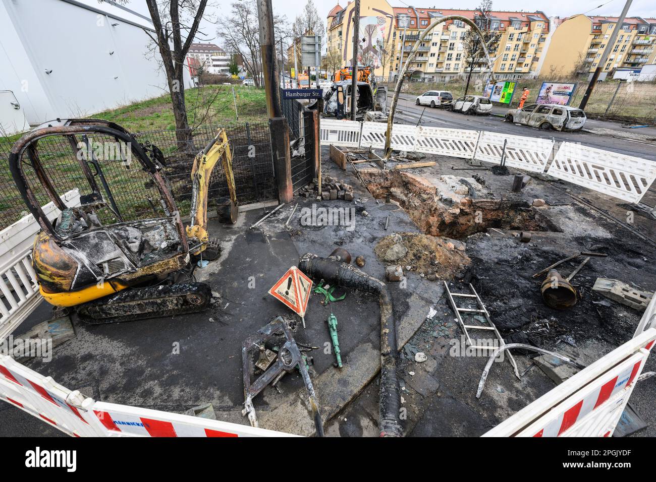 Dresden, Germany. 23rd Mar, 2023. A burnt-out excavator and cars stand ...