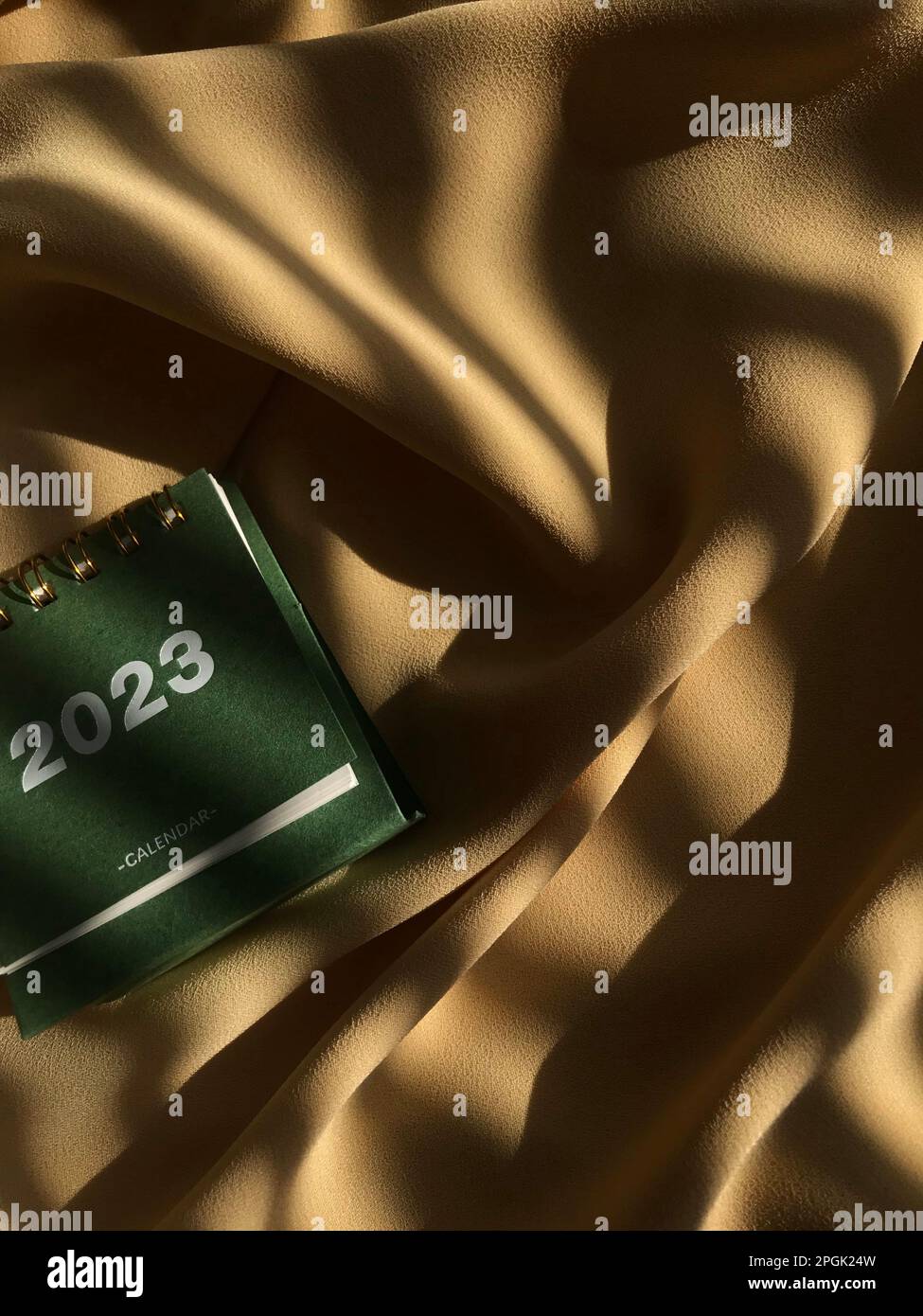 A 2023 calendar on a warm brown fabric illuminated by sunlight Stock ...