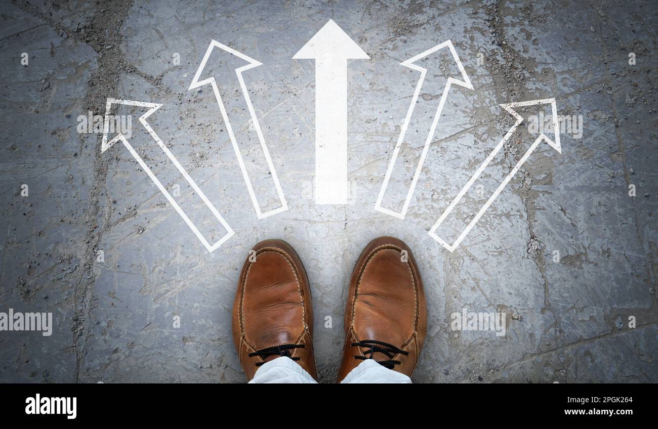 Brown leather shoes and five chalky arrows on asphalt - choice concept ...