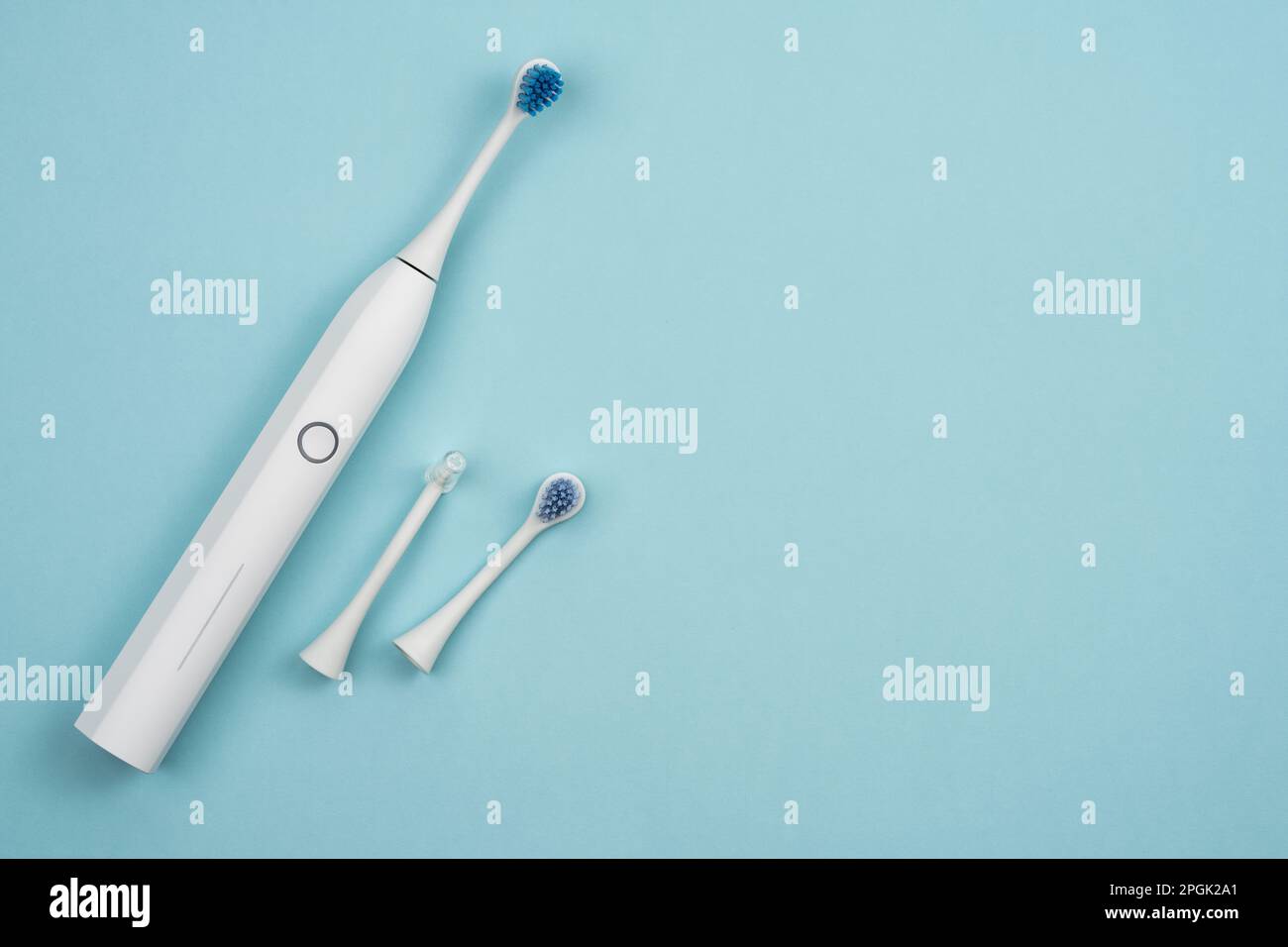 An electric toothbrush on a blue surface with its spare parts Stock ...