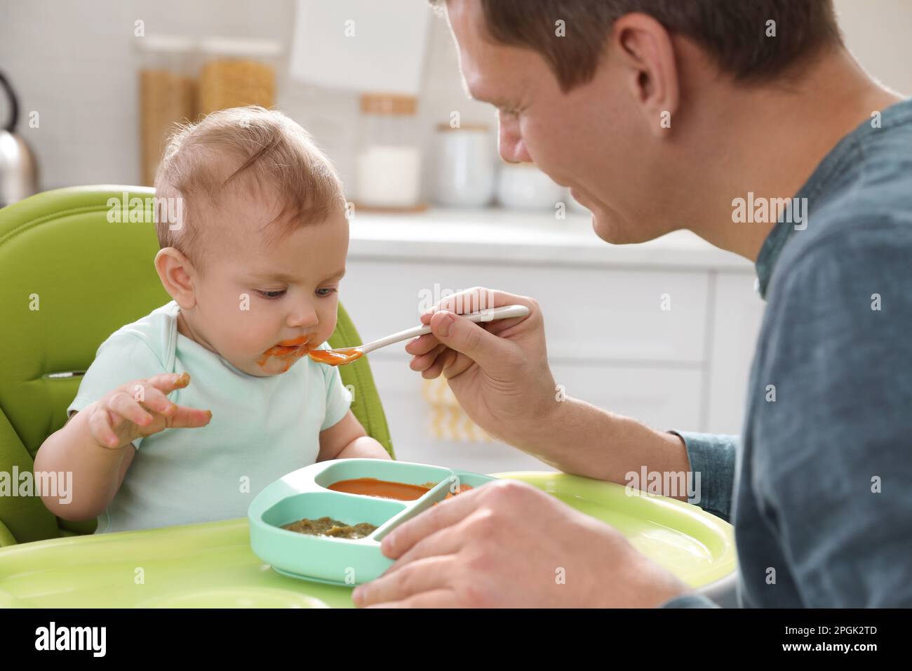 Father feeding baby daughter in chair hi-res stock photography and ...