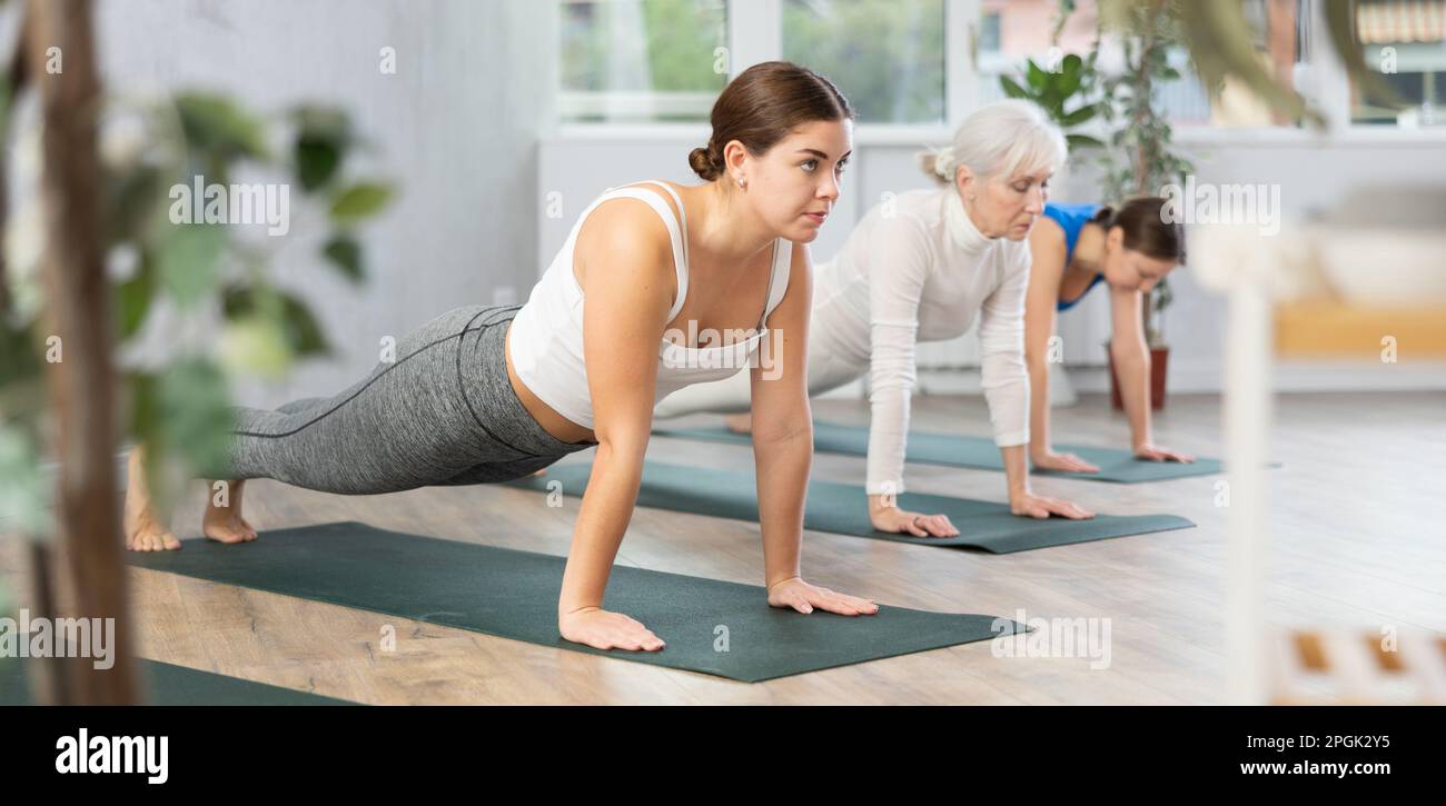 Young mature women pushing-up and being on hands and feet with straight ...