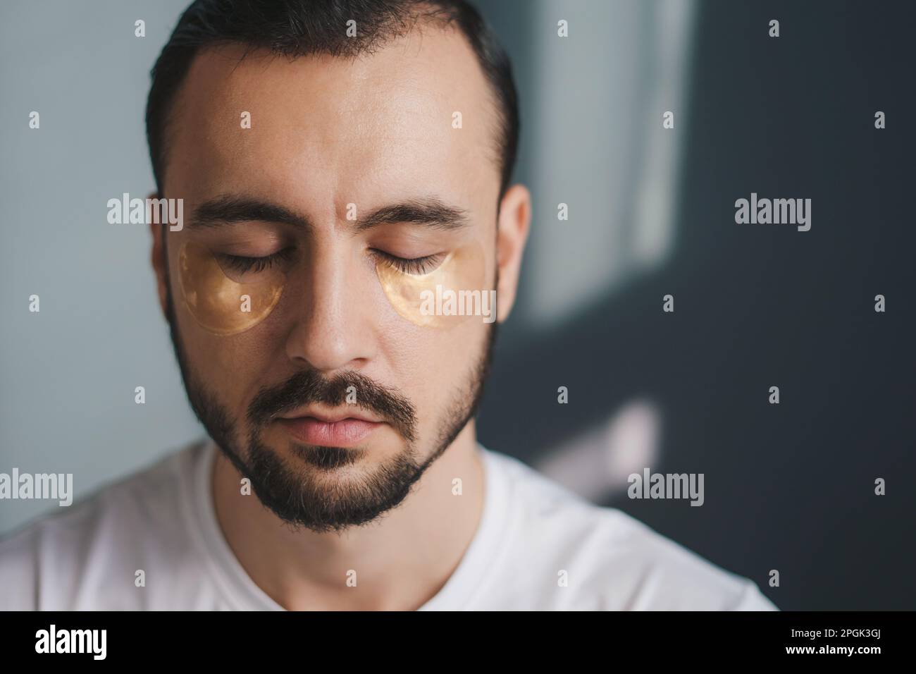 Caucasian calm man sitting on a sofa in a living room with closed eyes ...