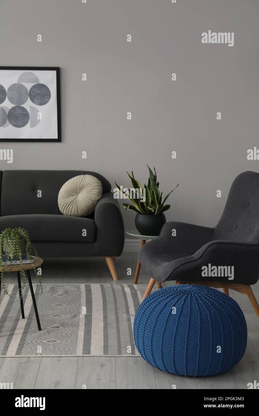 Stylish comfortable poufs and sofa in room. Home design Stock Photo - Alamy