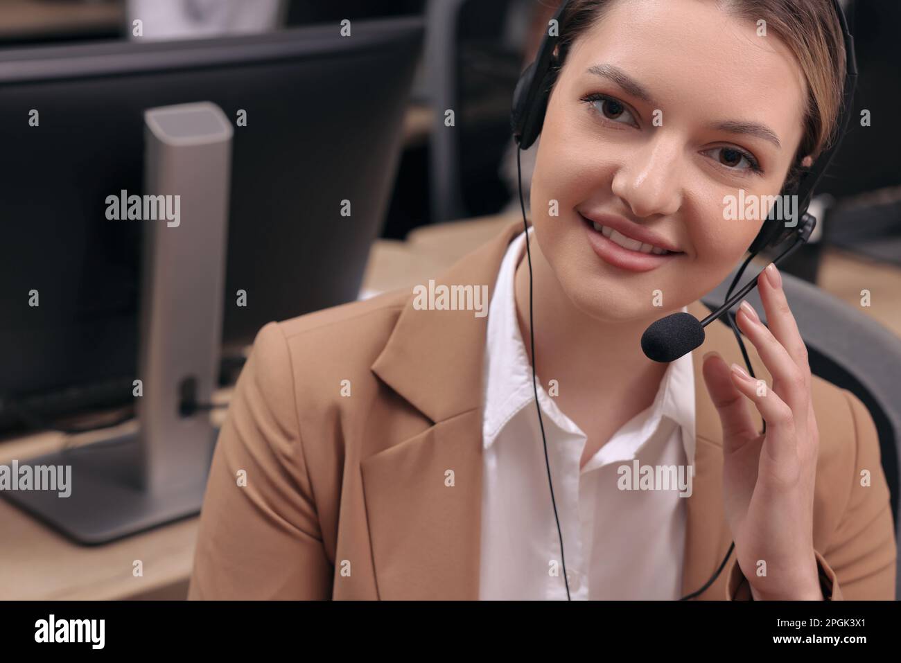 Young call center operator with headset working in modern office Stock Photo - Alamy