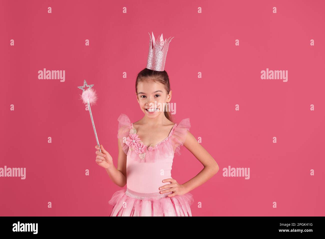 Cute girl in fairy dress with crown and magic wand on pink background ...