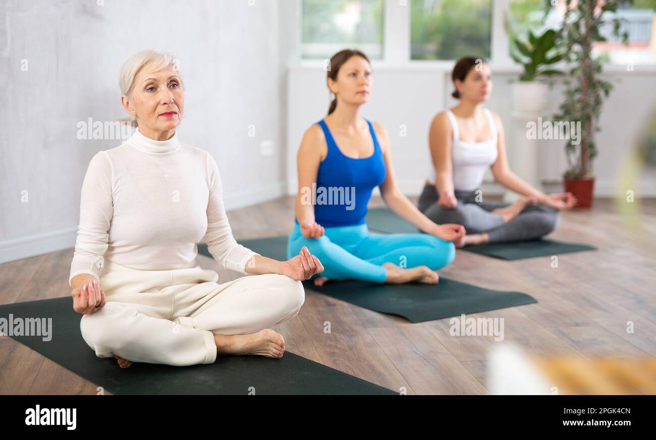 Elderly woman meditating in lotus position with hands in mudra Stock ...