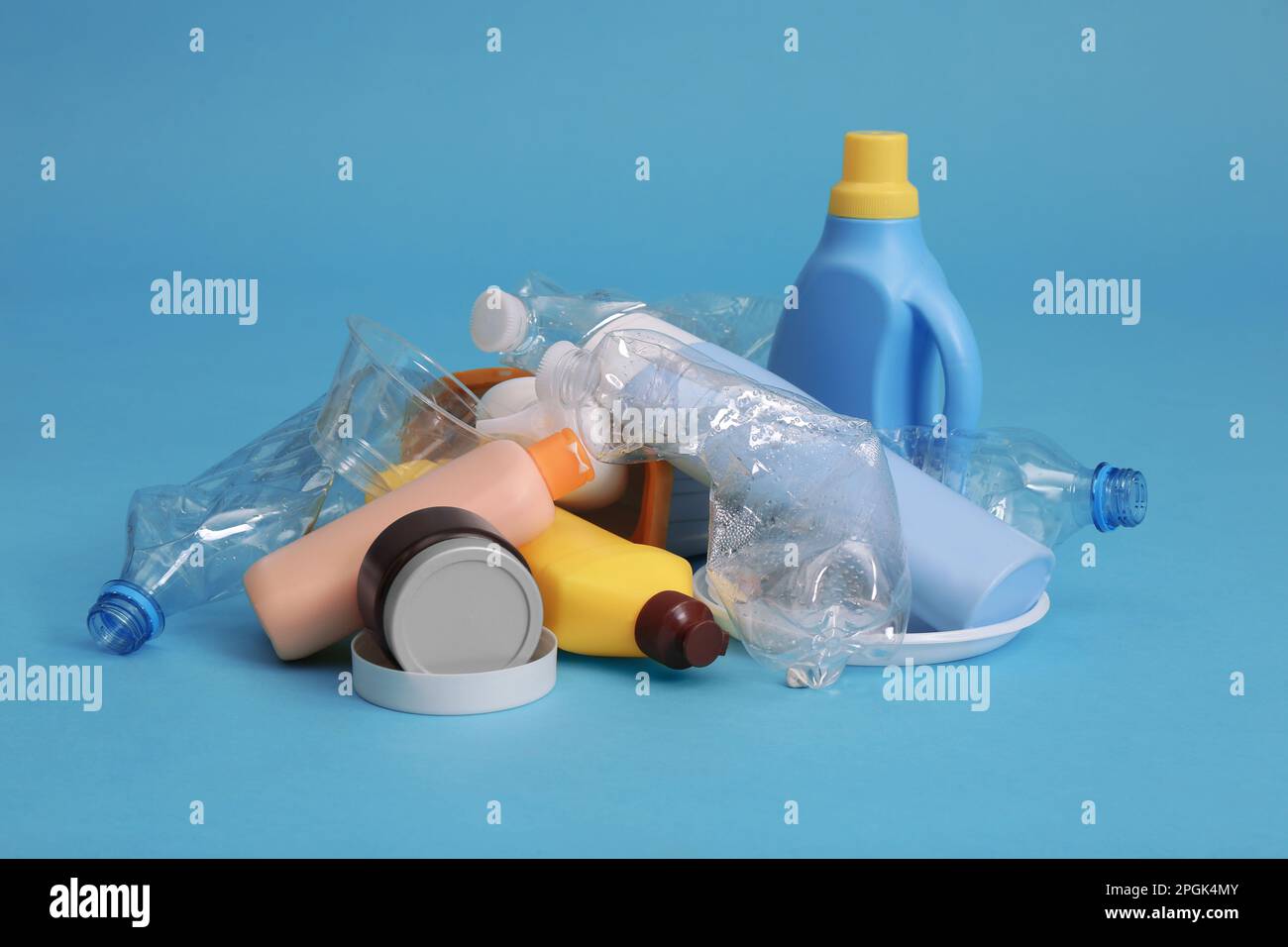 Pile of plastic garbage on light blue background Stock Photo - Alamy
