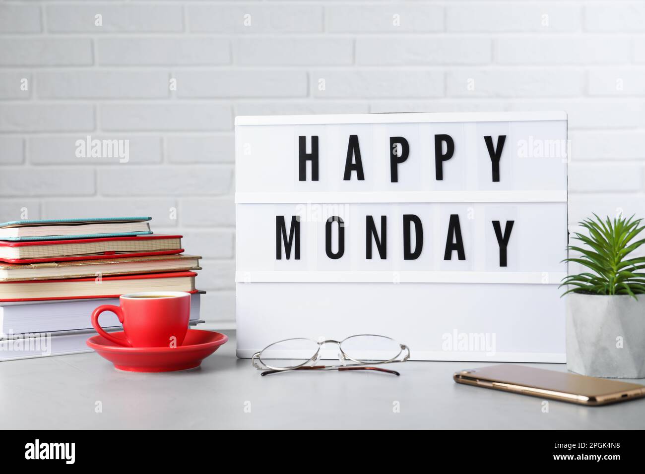 Light box with message Happy Monday, office stationery and cup of ...