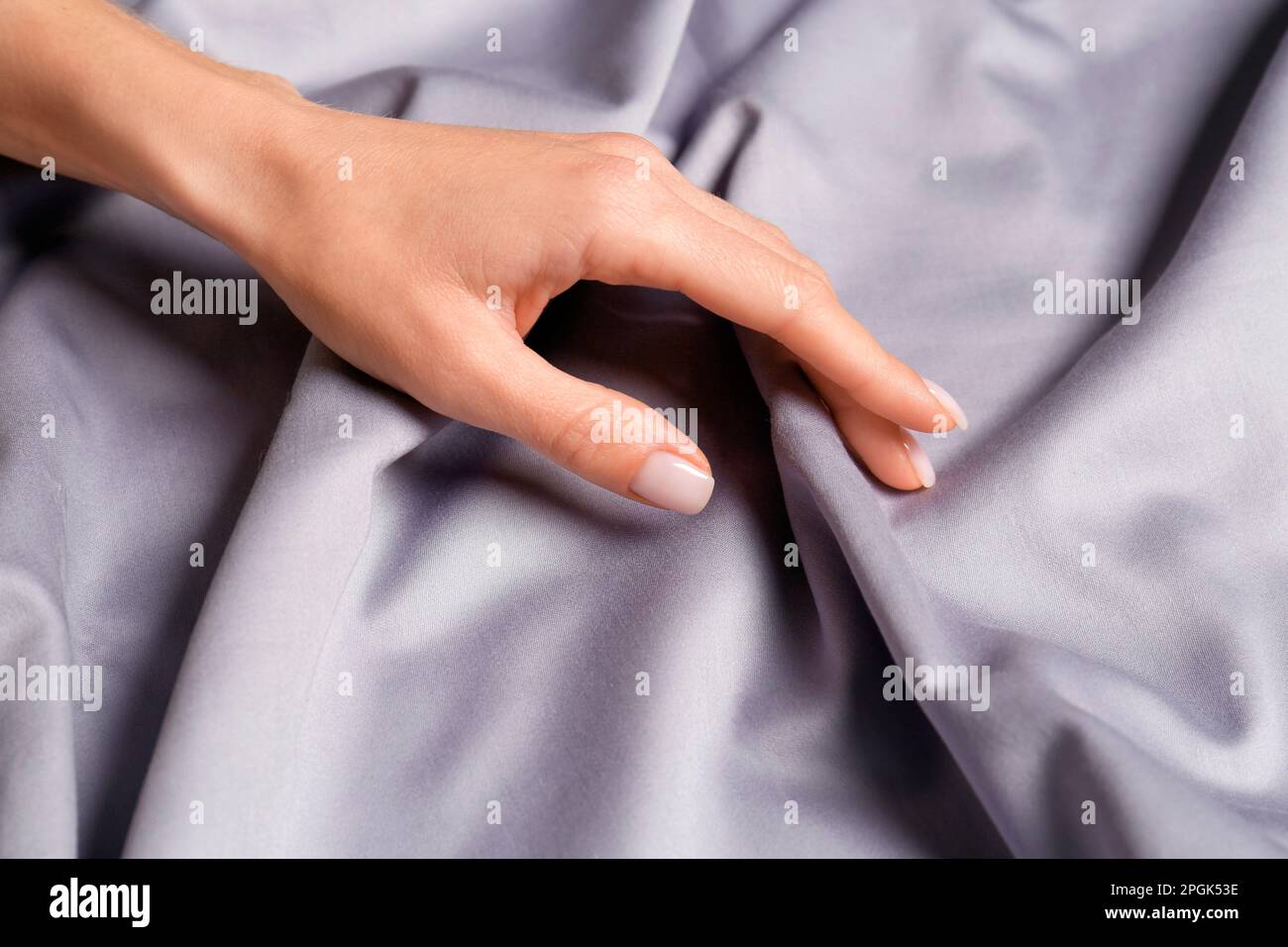 Woman touching soft silver fabric, closeup view Stock Photo - Alamy