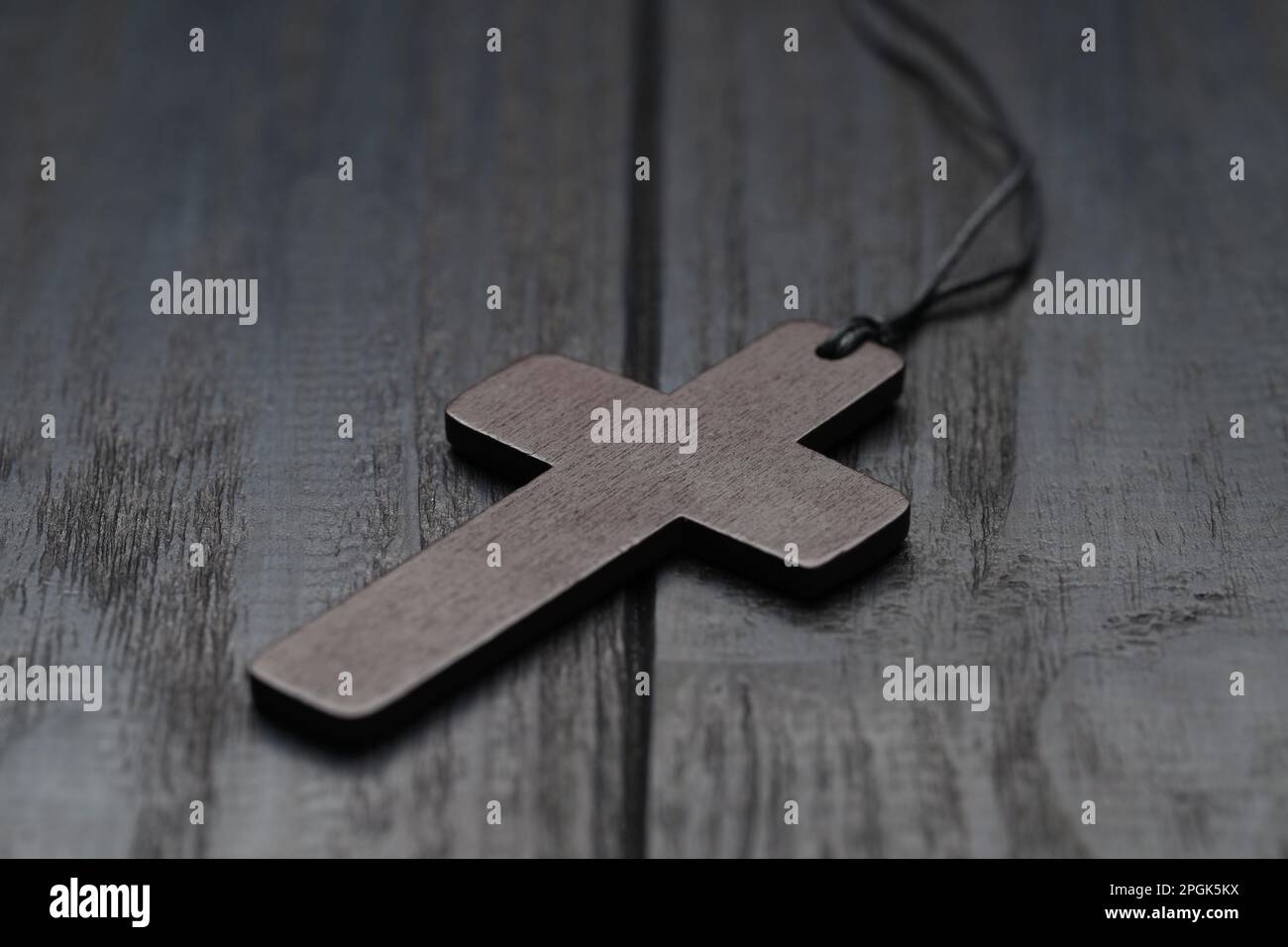 Christian cross on black wooden table, closeup Stock Photo - Alamy